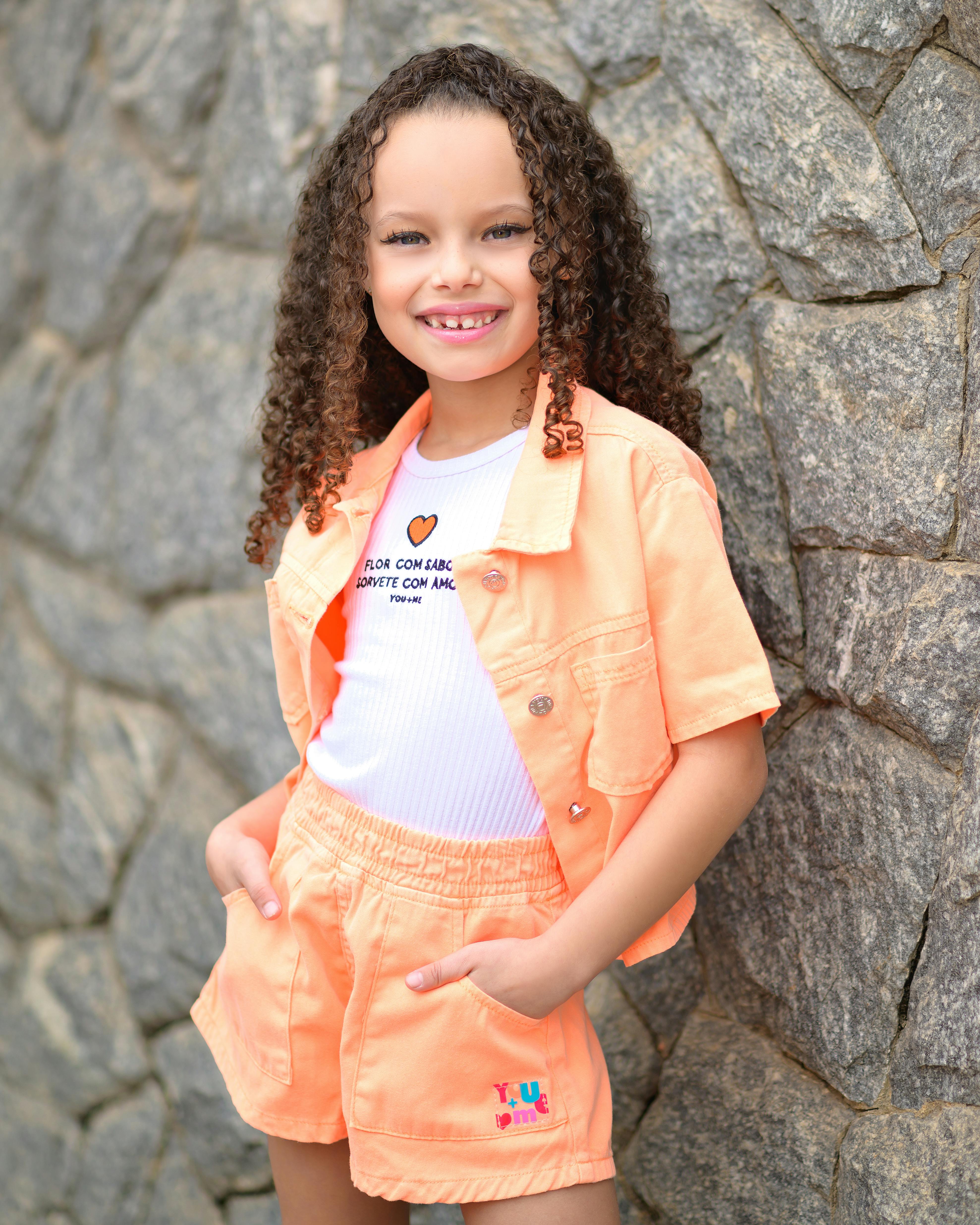 Smiling Girl Posing near Stone Wall · Free Stock Photo