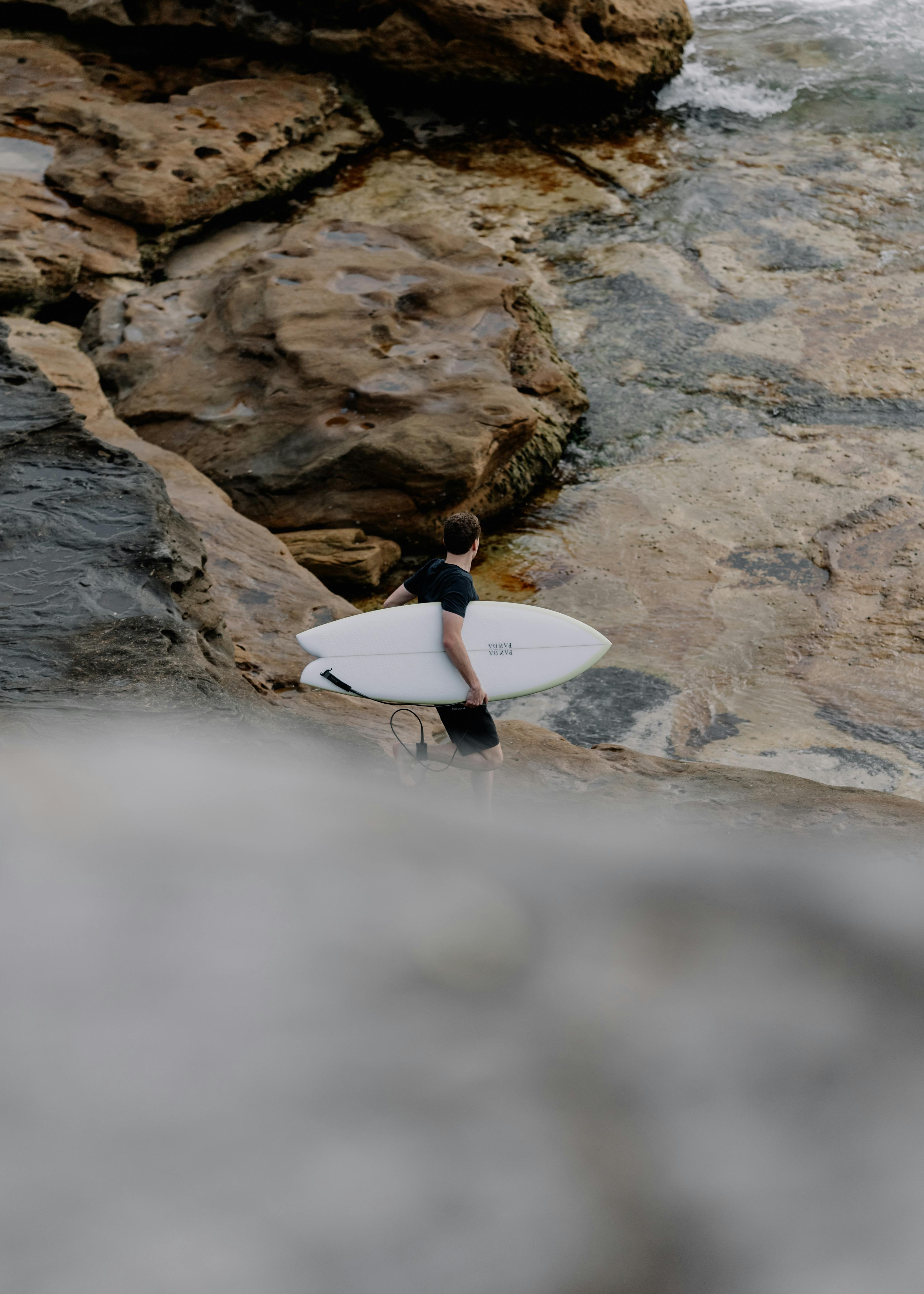 Man with Board near Cliffs · Free Stock Photo