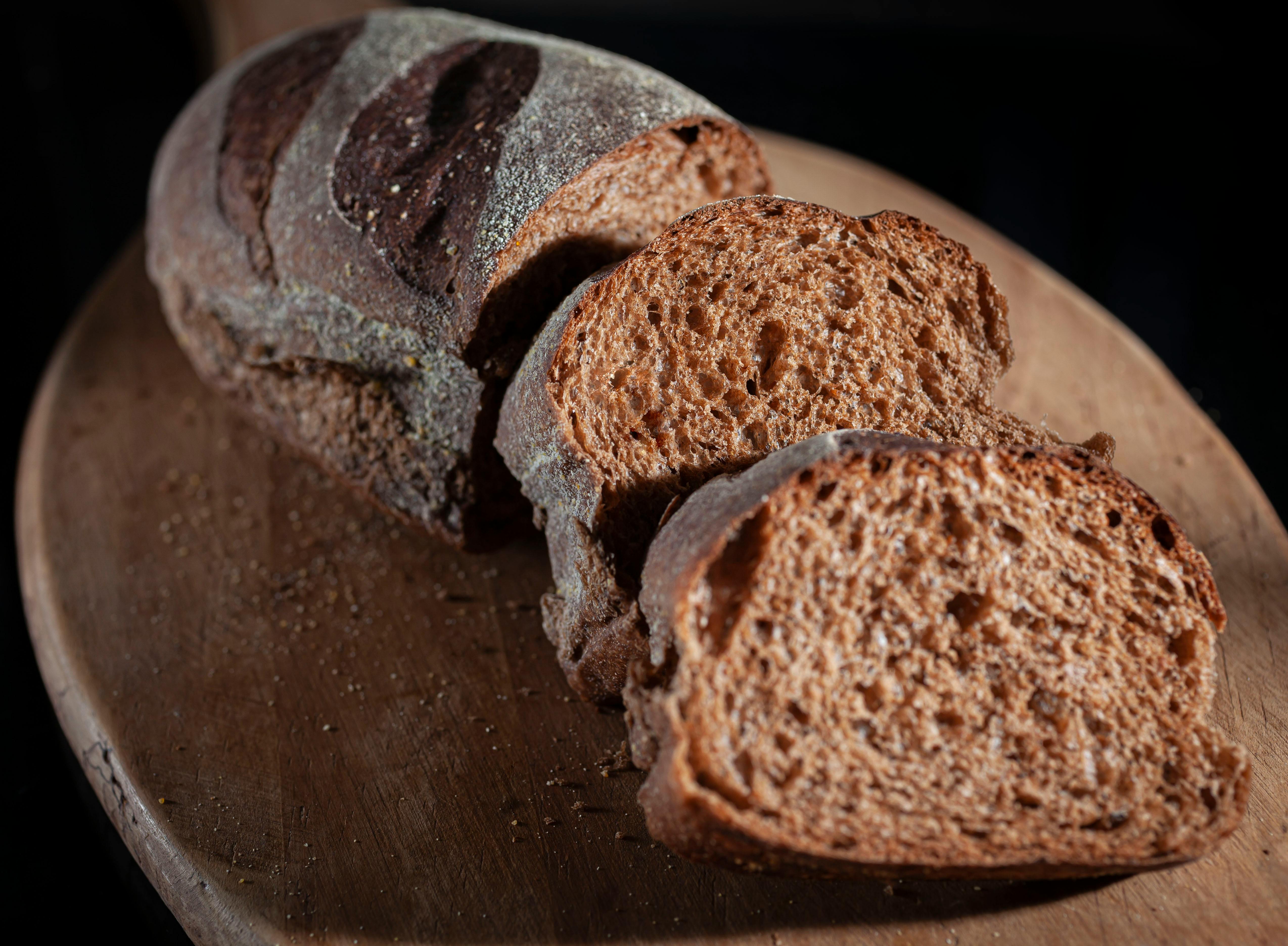 Sliced Bread and Stainless Steel Knife on Top of Brown Wooden Chopping ...