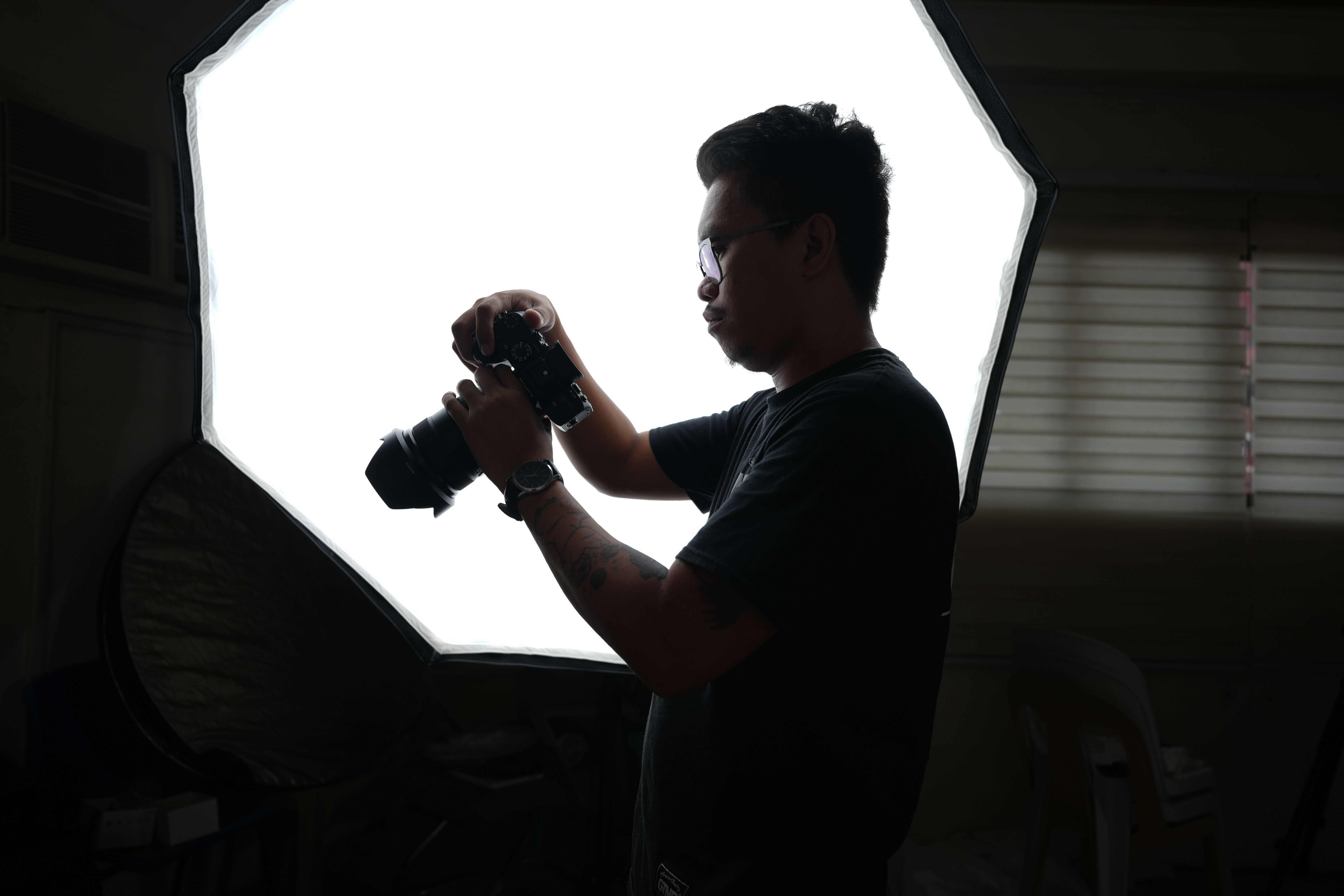 Photographer Holding Camera in Studio · Free Stock Photo