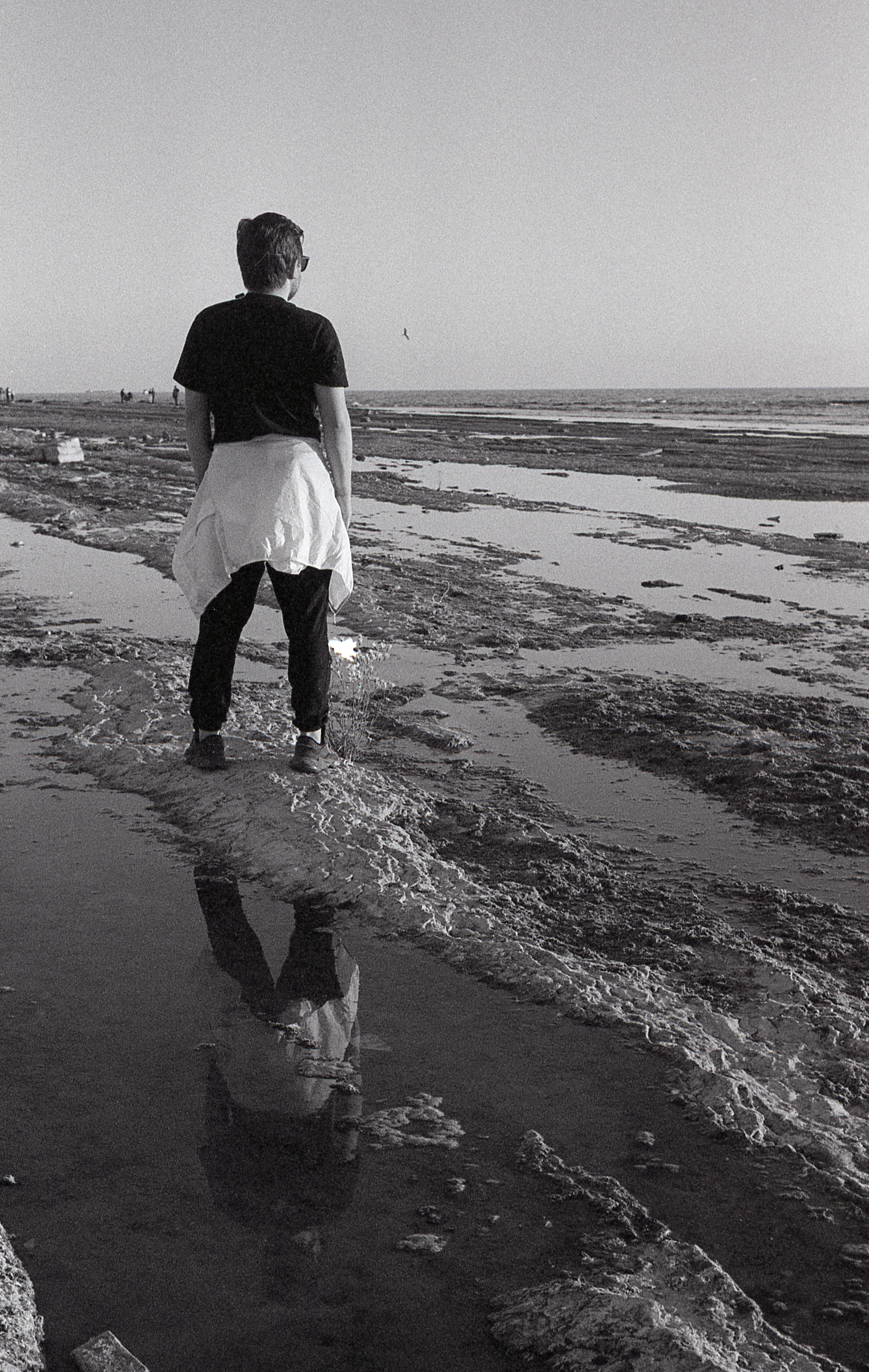 Man Standing on Puddles in Black and White · Free Stock Photo