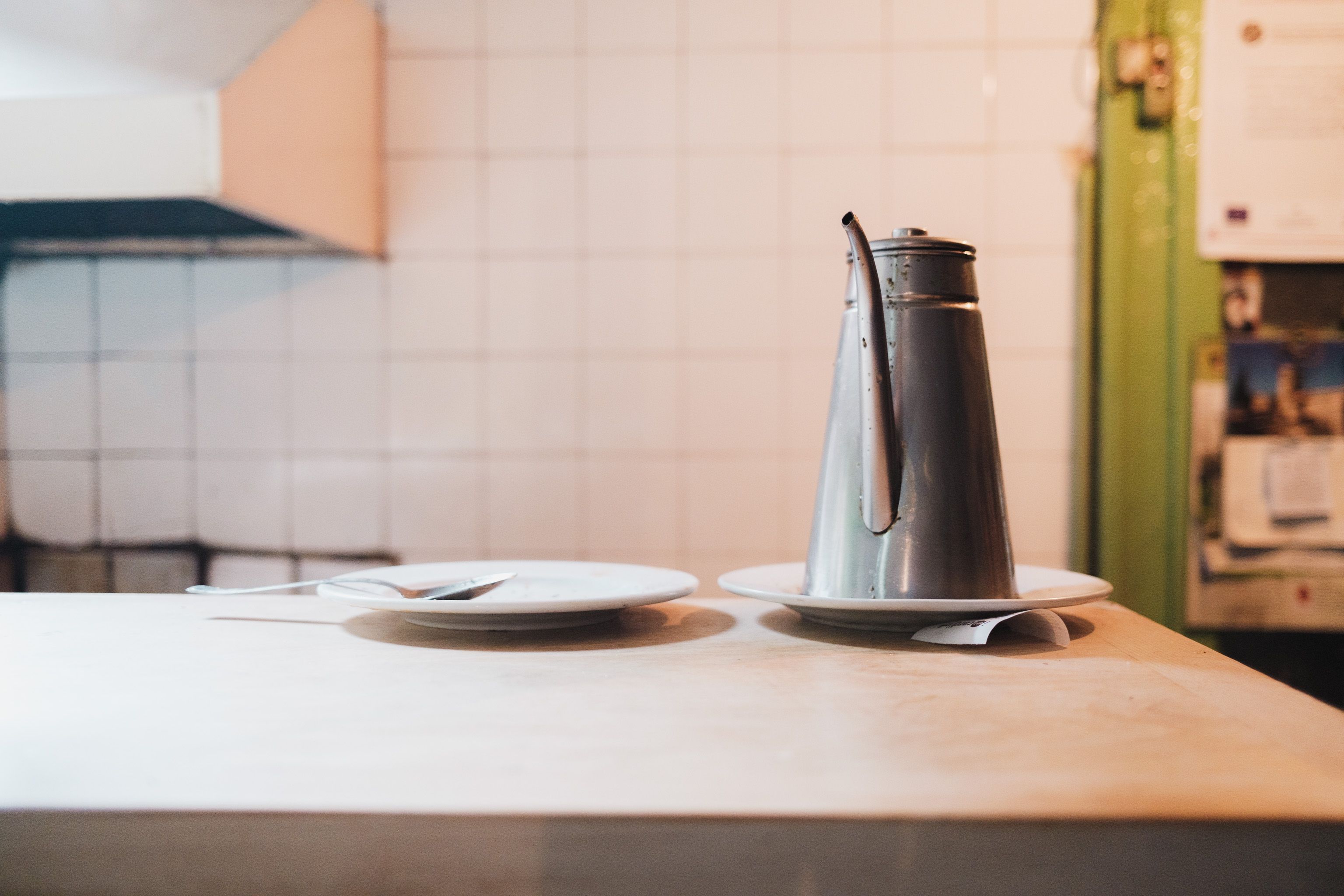 A coffee pot and a plate on a counter · Free Stock Photo