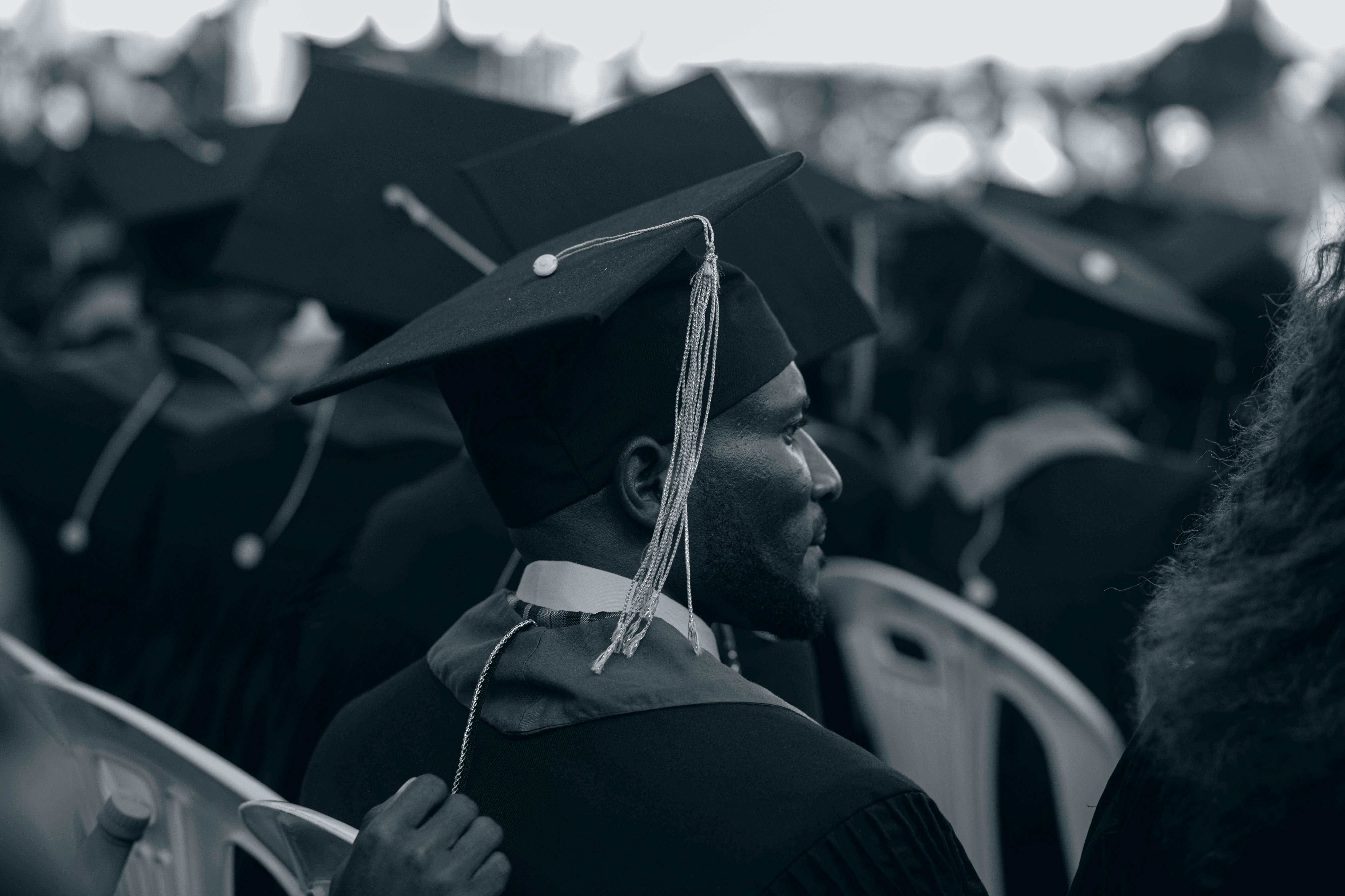 Person in Blue Vest Holding an Academic Cap · Free Stock Photo