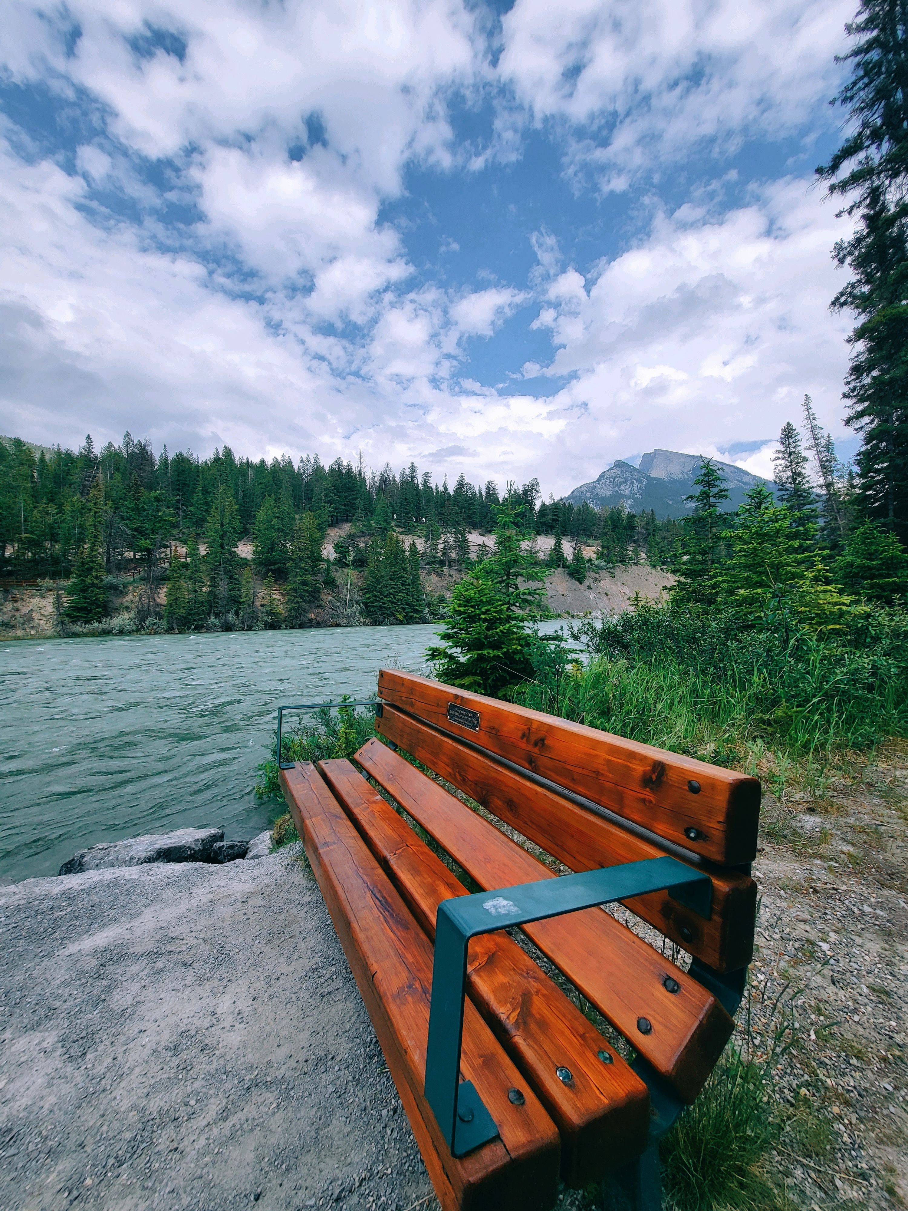 A Bench near the River in a Mountain Valley · Free Stock Photo