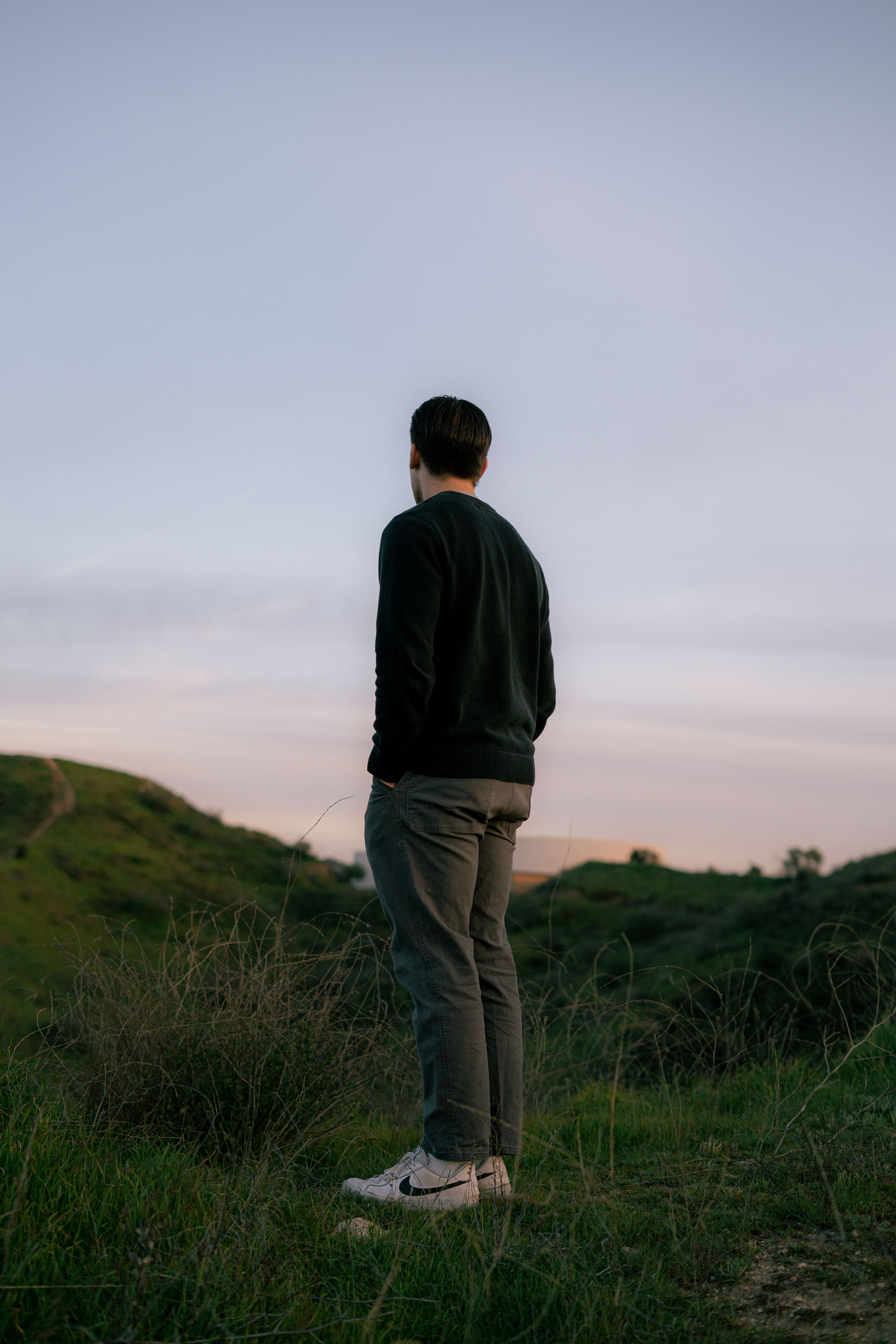 Man in Sweatshirt Standing on Meadow · Free Stock Photo