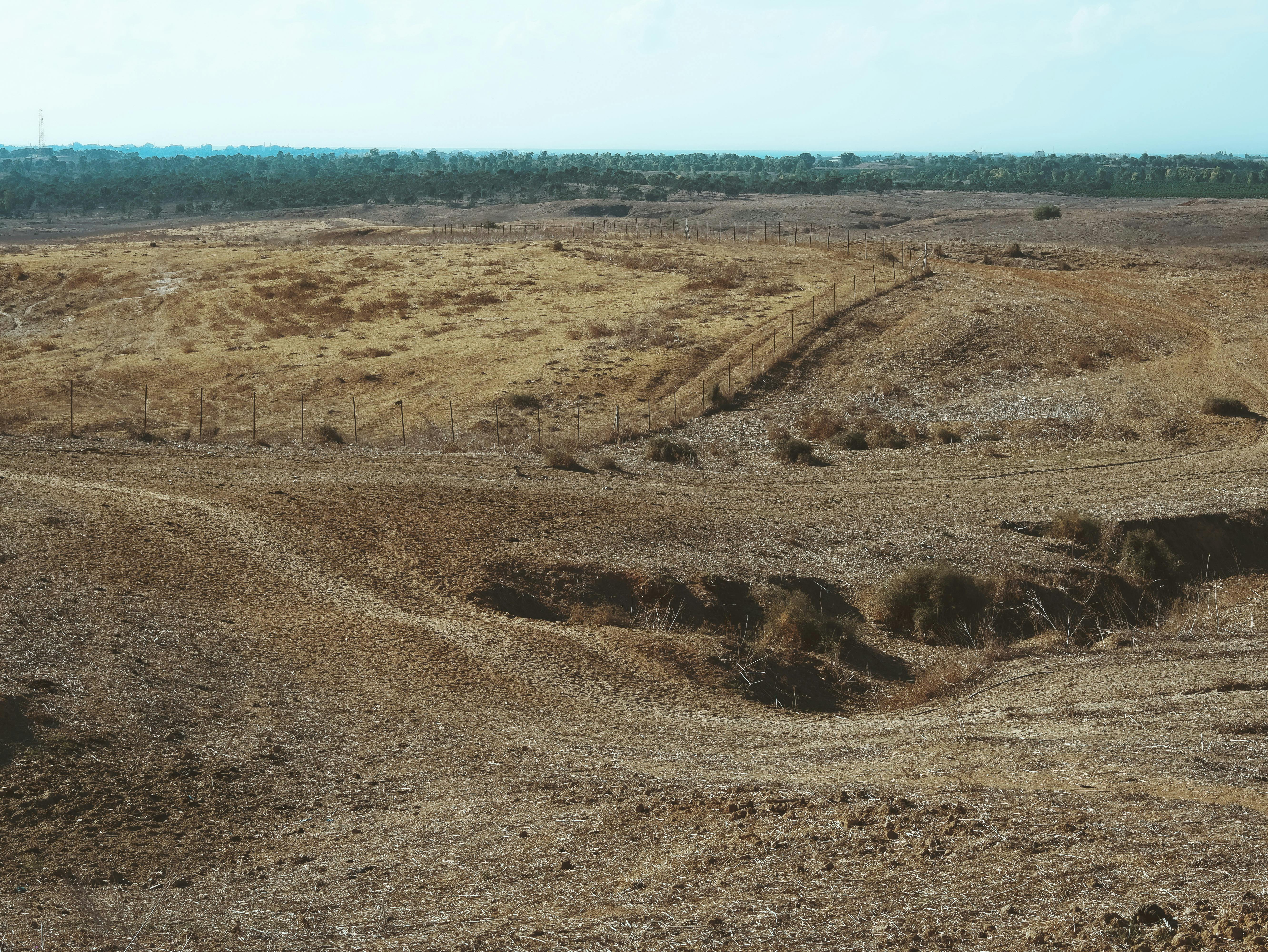 Landscape of an Empty Land covered in Soil and Dry Grass · Free Stock Photo