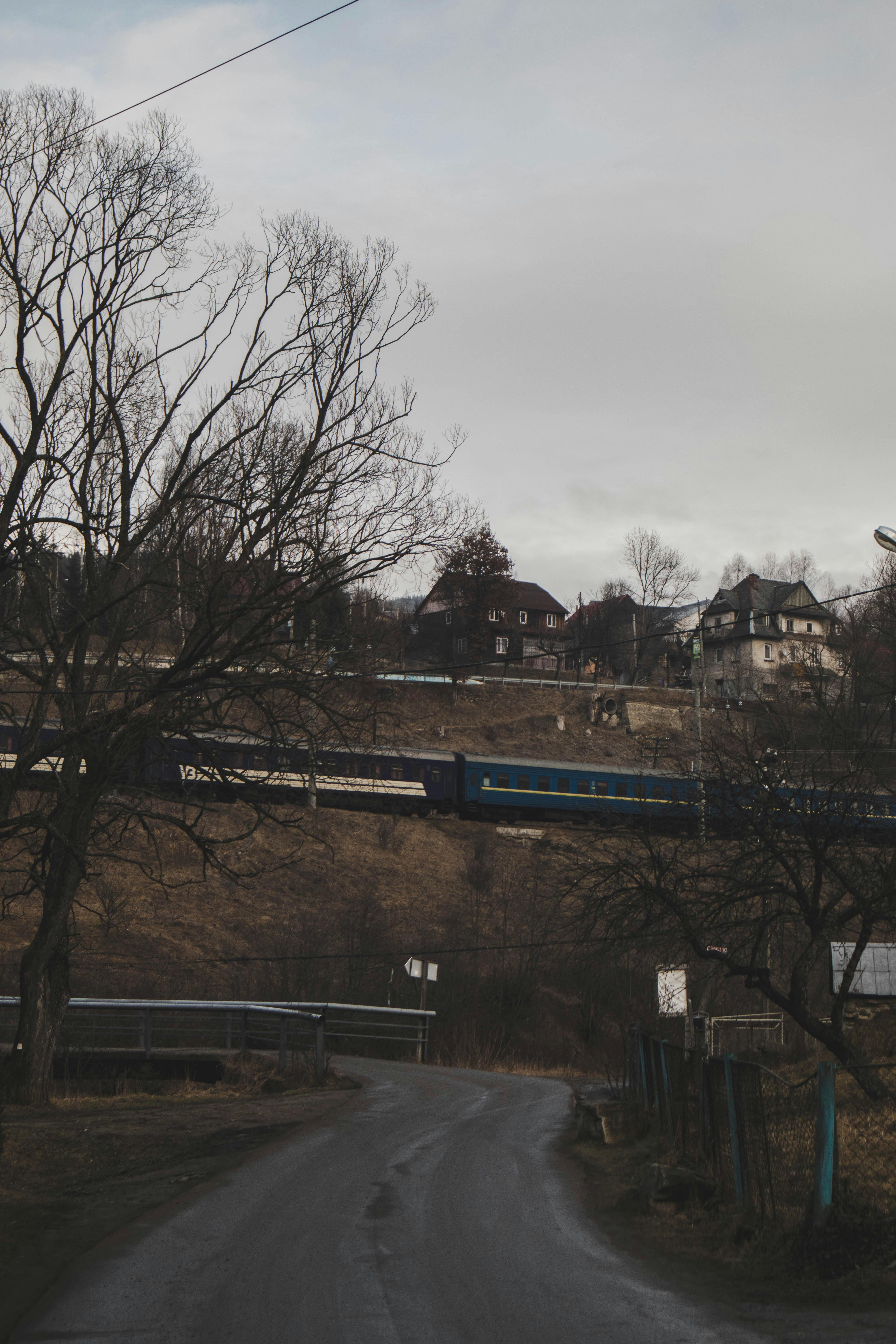 Train on Hill over Road in Village · Free Stock Photo