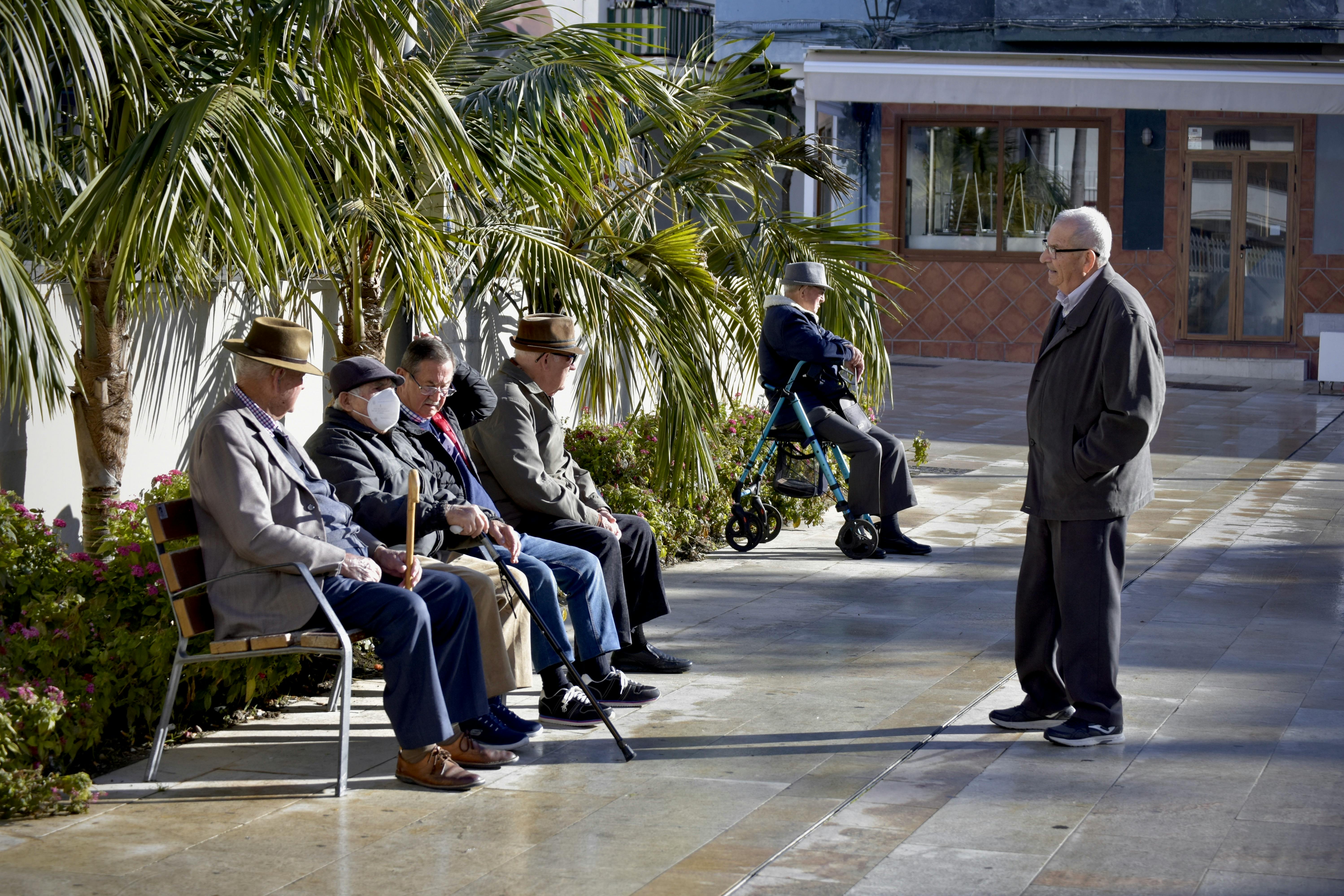 A Group of Elderly Men Sitting on a Bench in City and Talking · Free ...