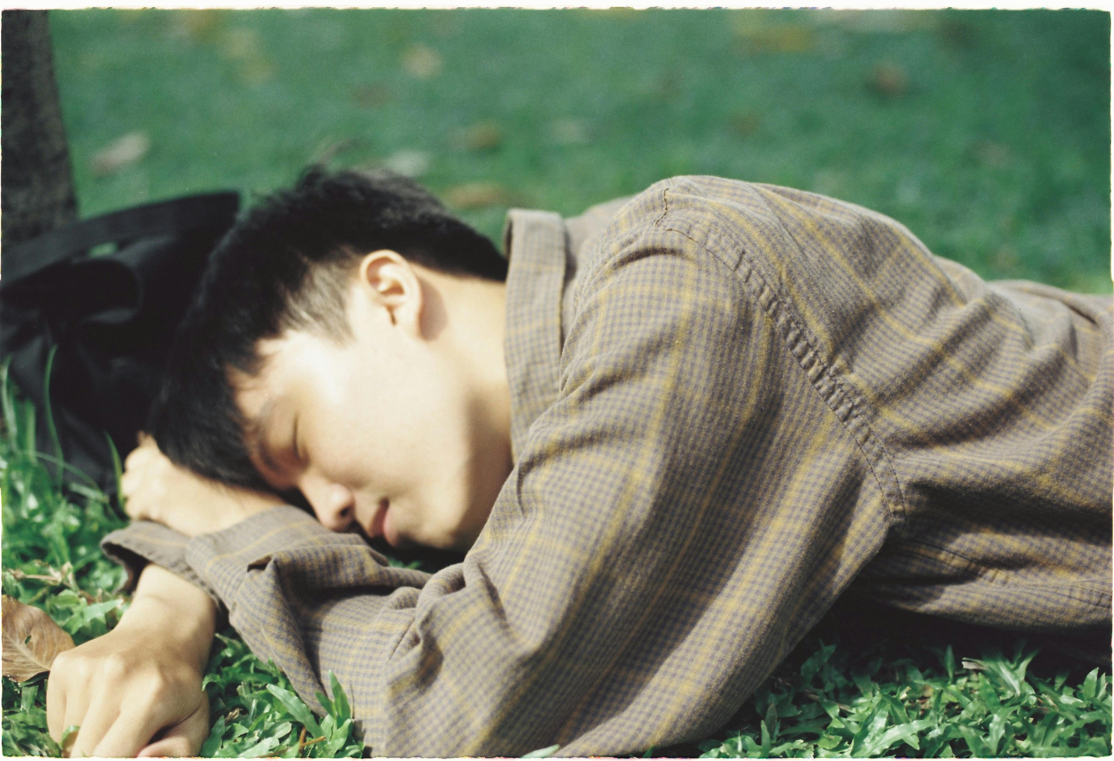 Young Man Sleeping on Grass Ground in Park · Free Stock Photo