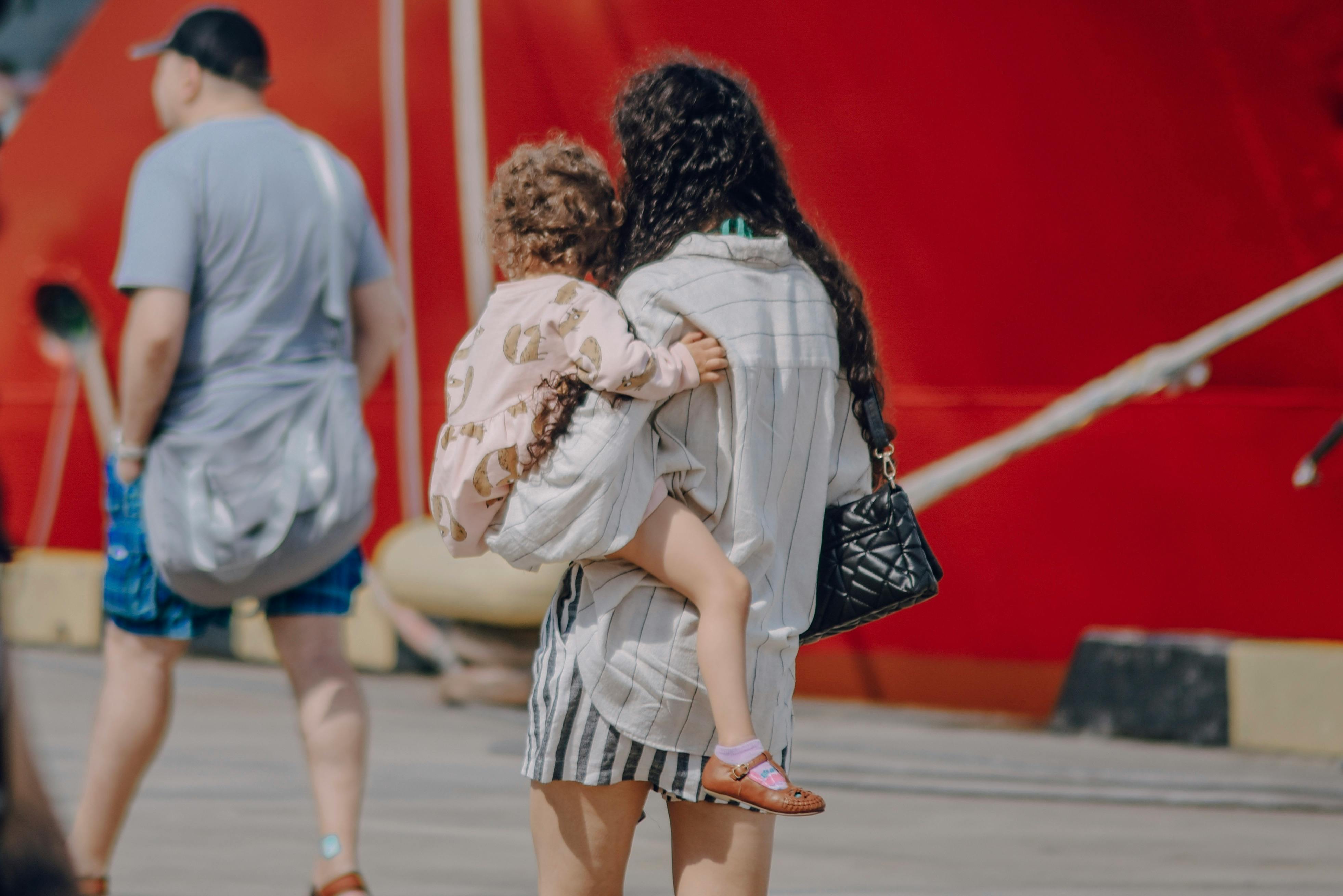 Photo of a Mother Carrying a Sleeping Baby · Free Stock Photo
