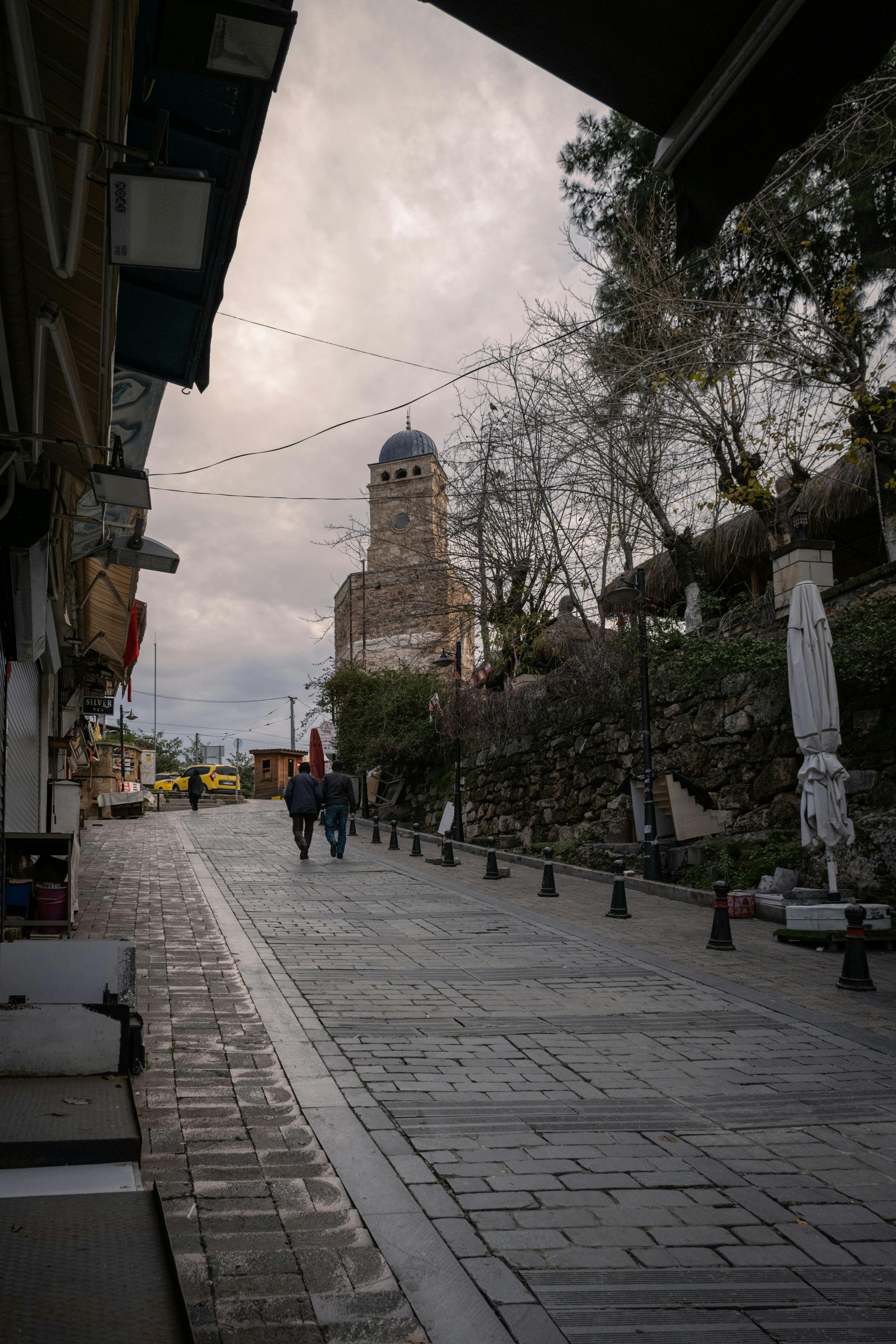 Men Walking on Paving Stone Street · Free Stock Photo