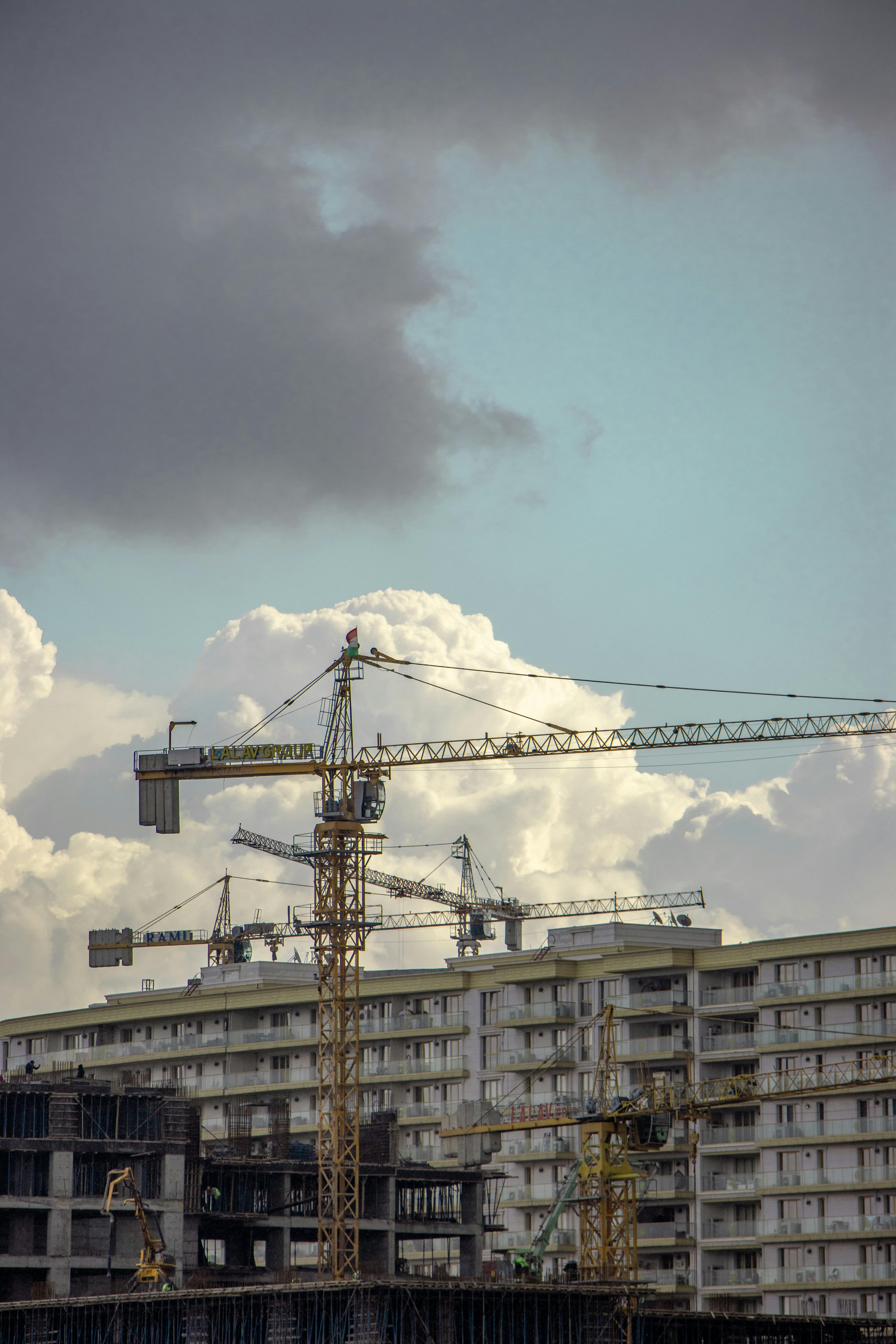 Rain Cloud and Clouds over Construction Cranes in Town · Free Stock Photo