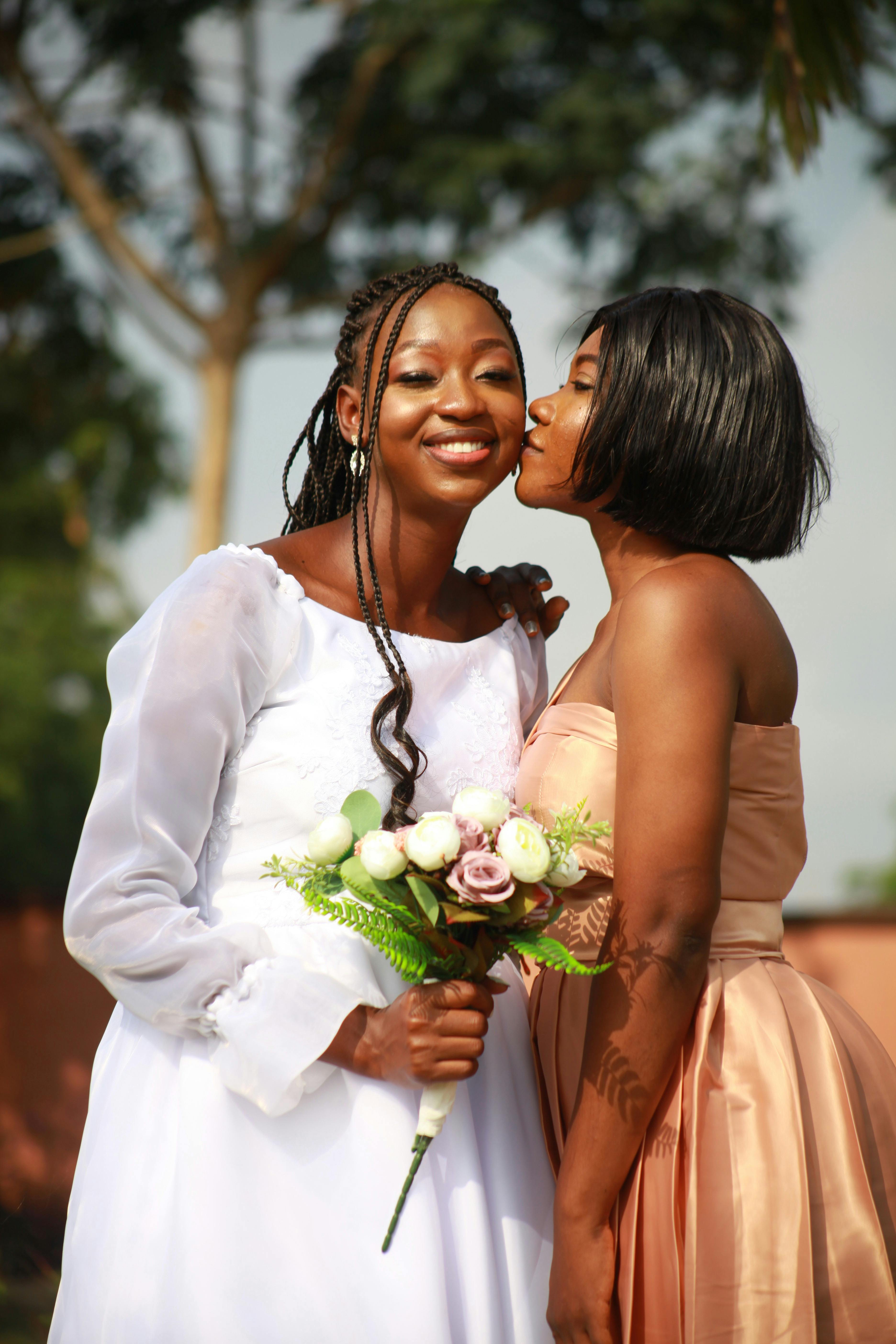 A Beautiful Woman in White Wedding Gown Smiling while Talking to Her ...
