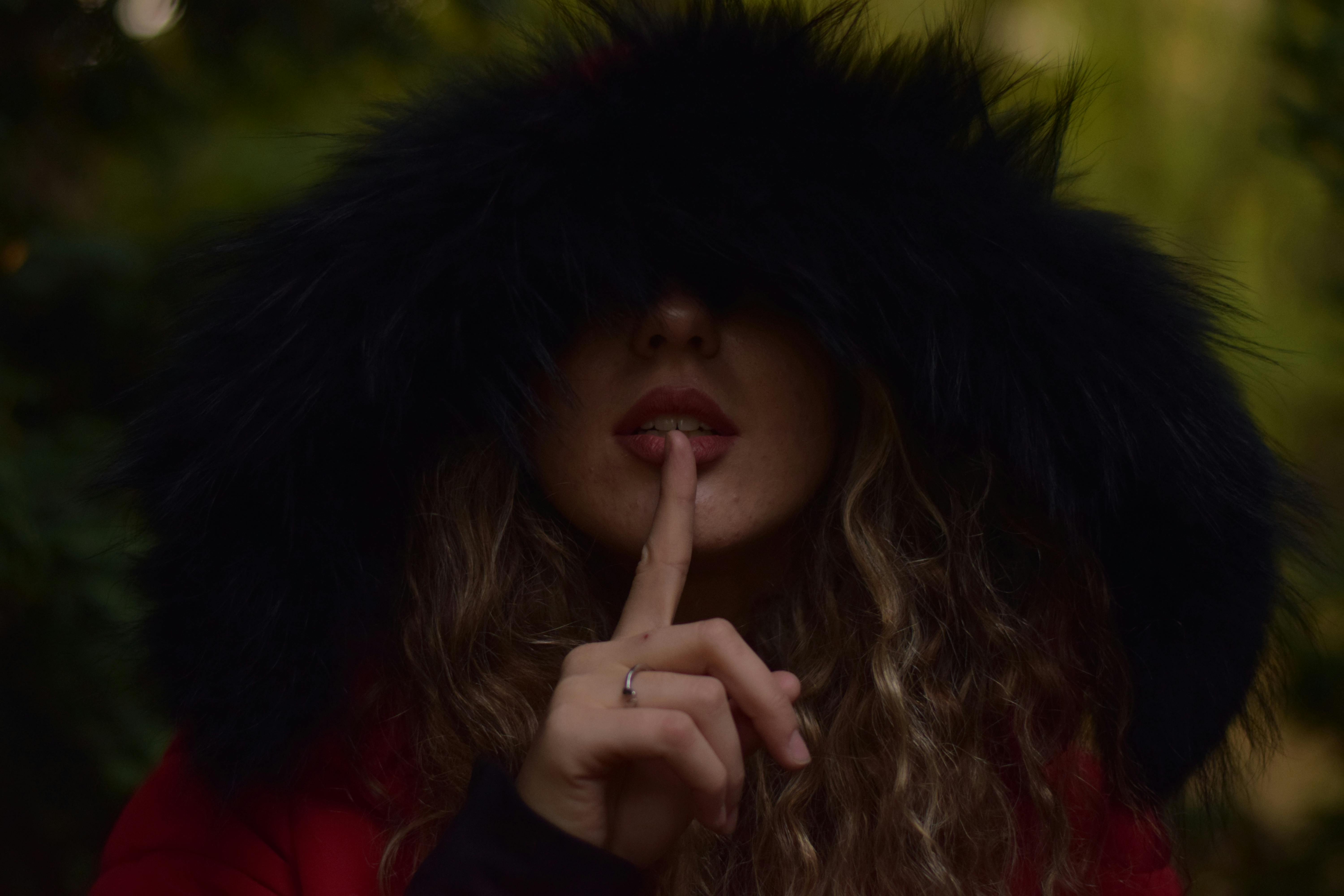 Woman Holding a Finger over Her Lips · Free Stock Photo