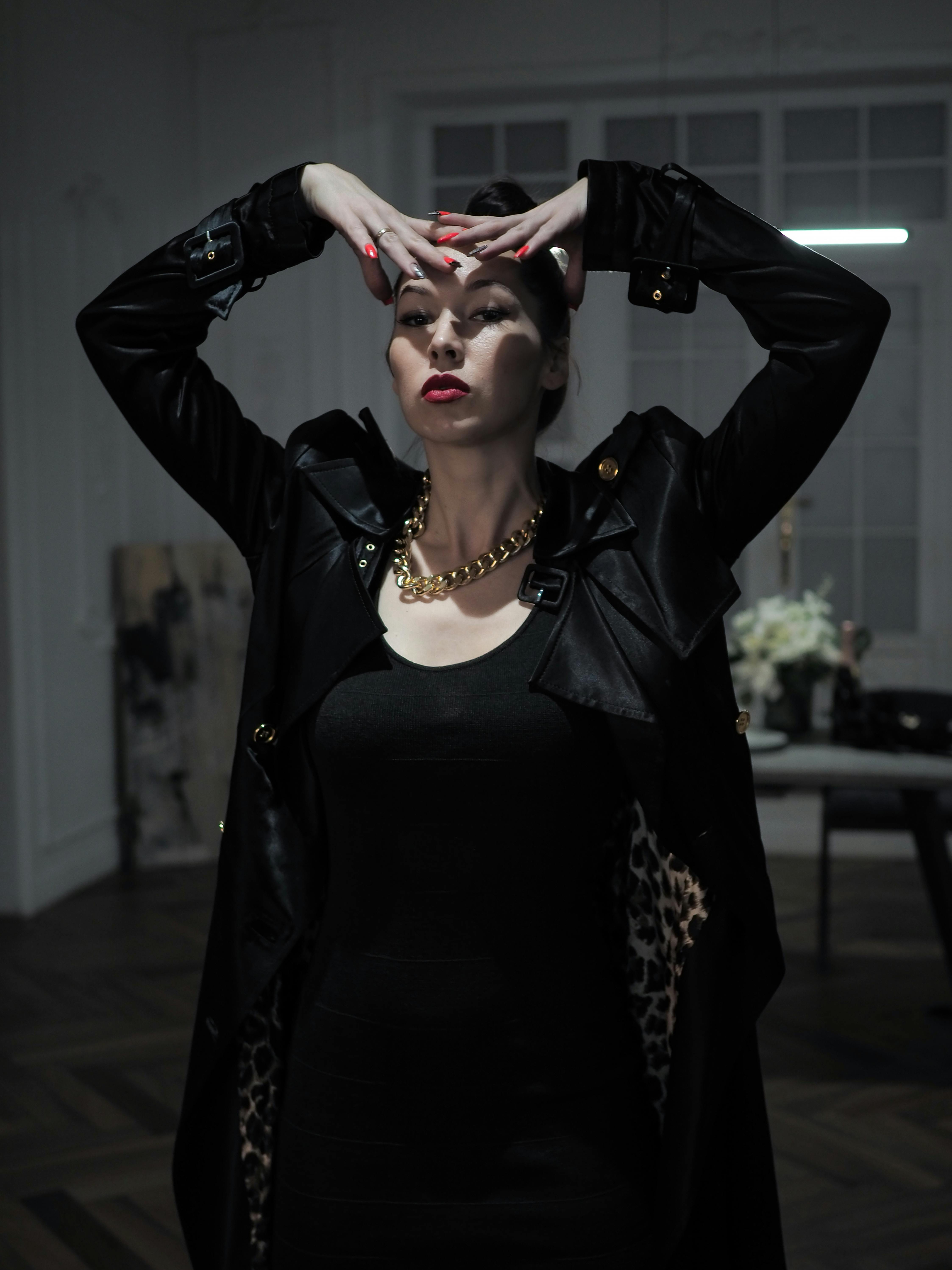 Woman in Black Jacket Posing with Arms Raised · Free Stock Photo