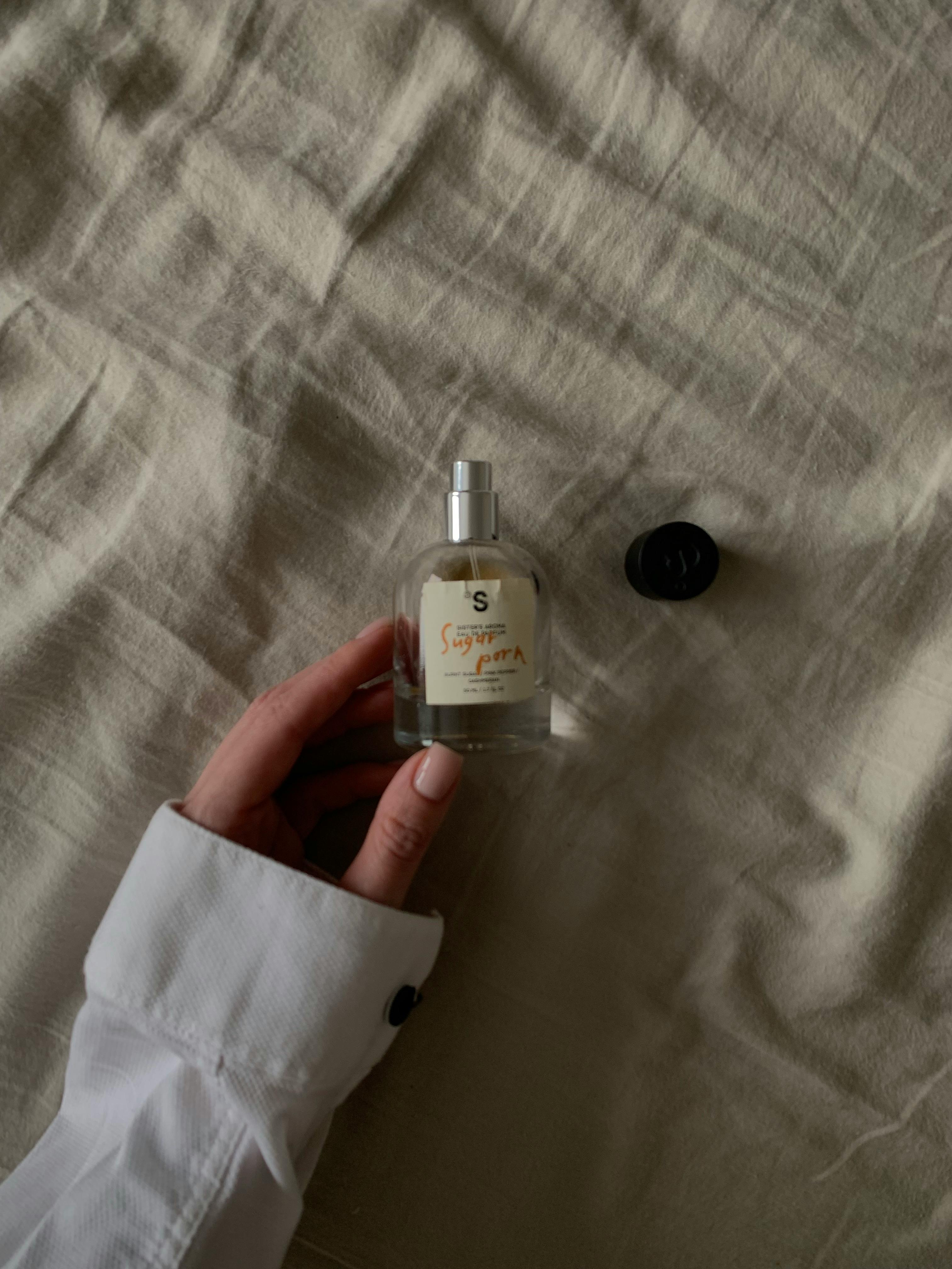 Closeup of a young woman applying perfume · Free Stock Photo