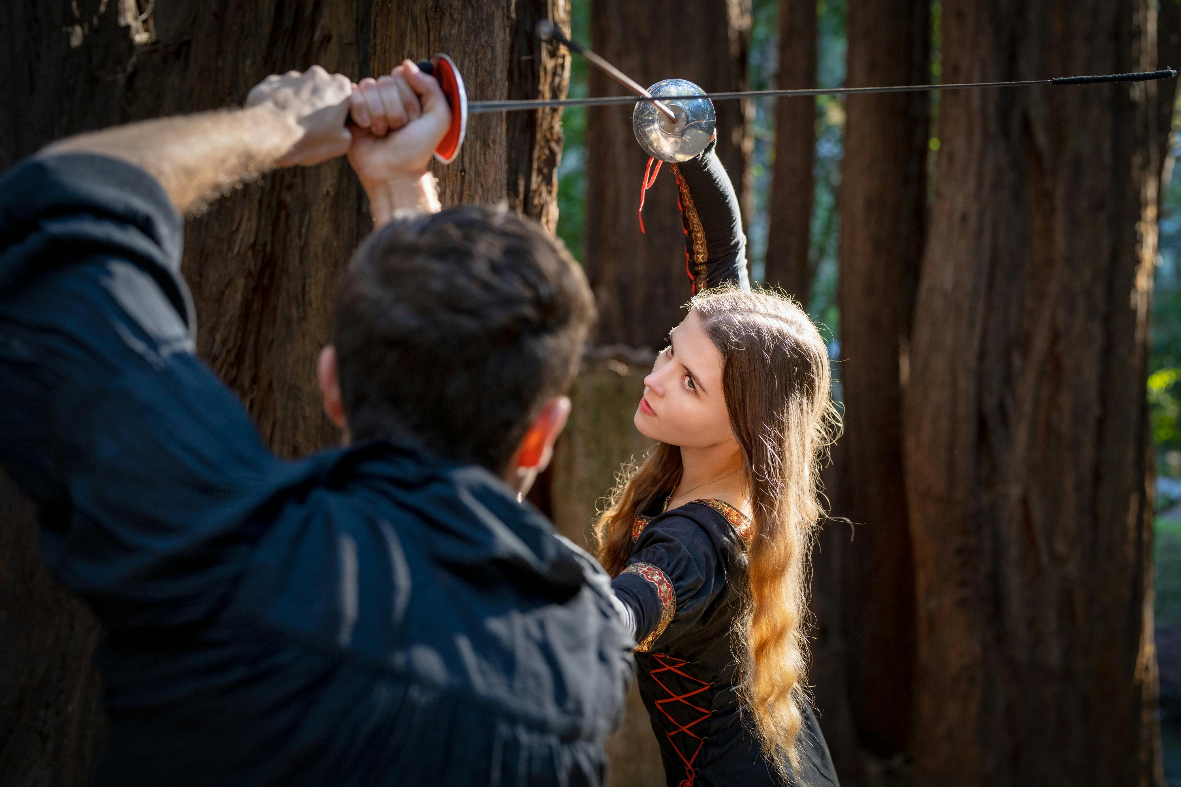 Man and Woman in Costumes Fighting with Swords during a Historical ...