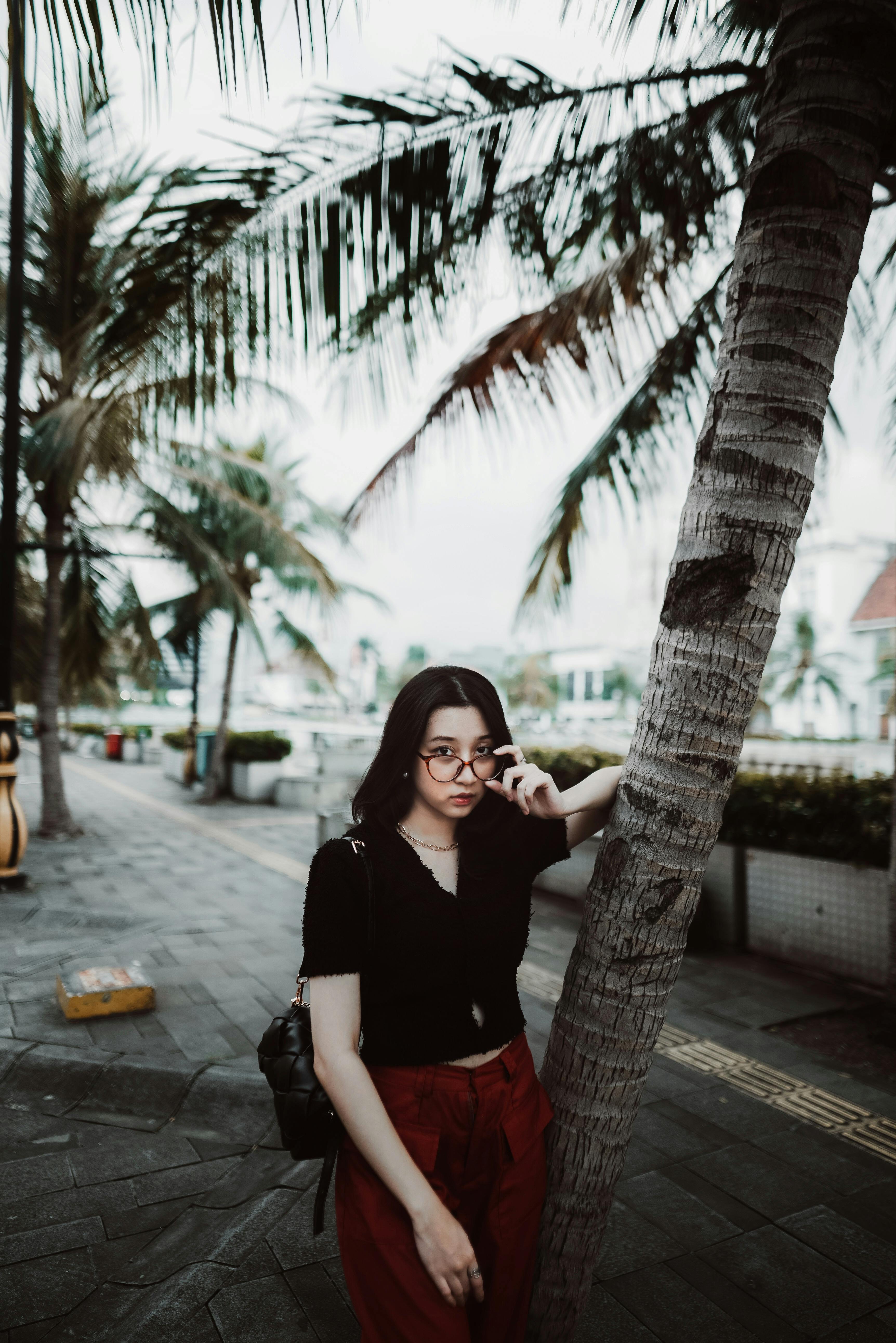 Girl Leaning on a Palm Tree · Free Stock Photo