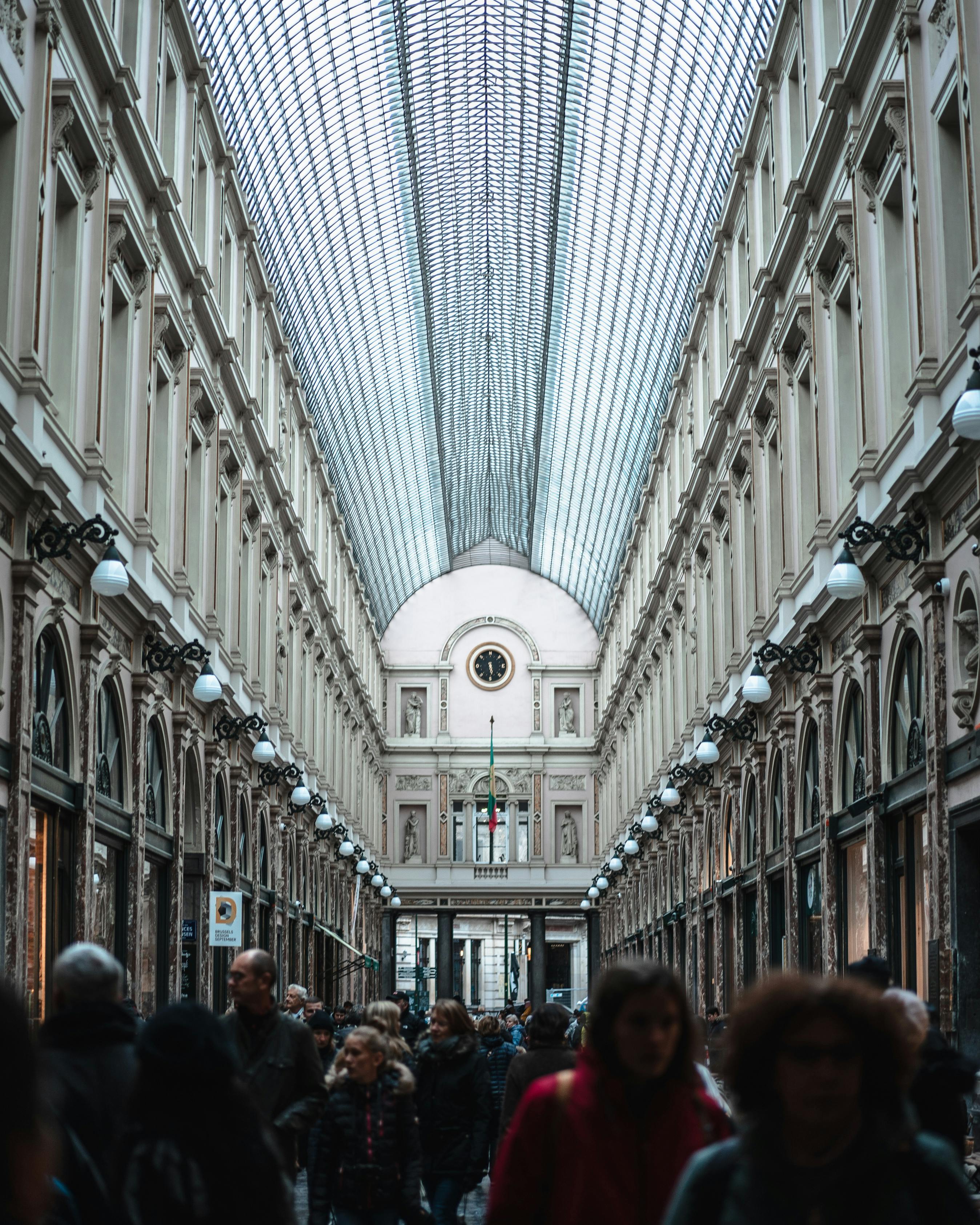 Group of People Walking on Hallway Inside Building · Free Stock Photo