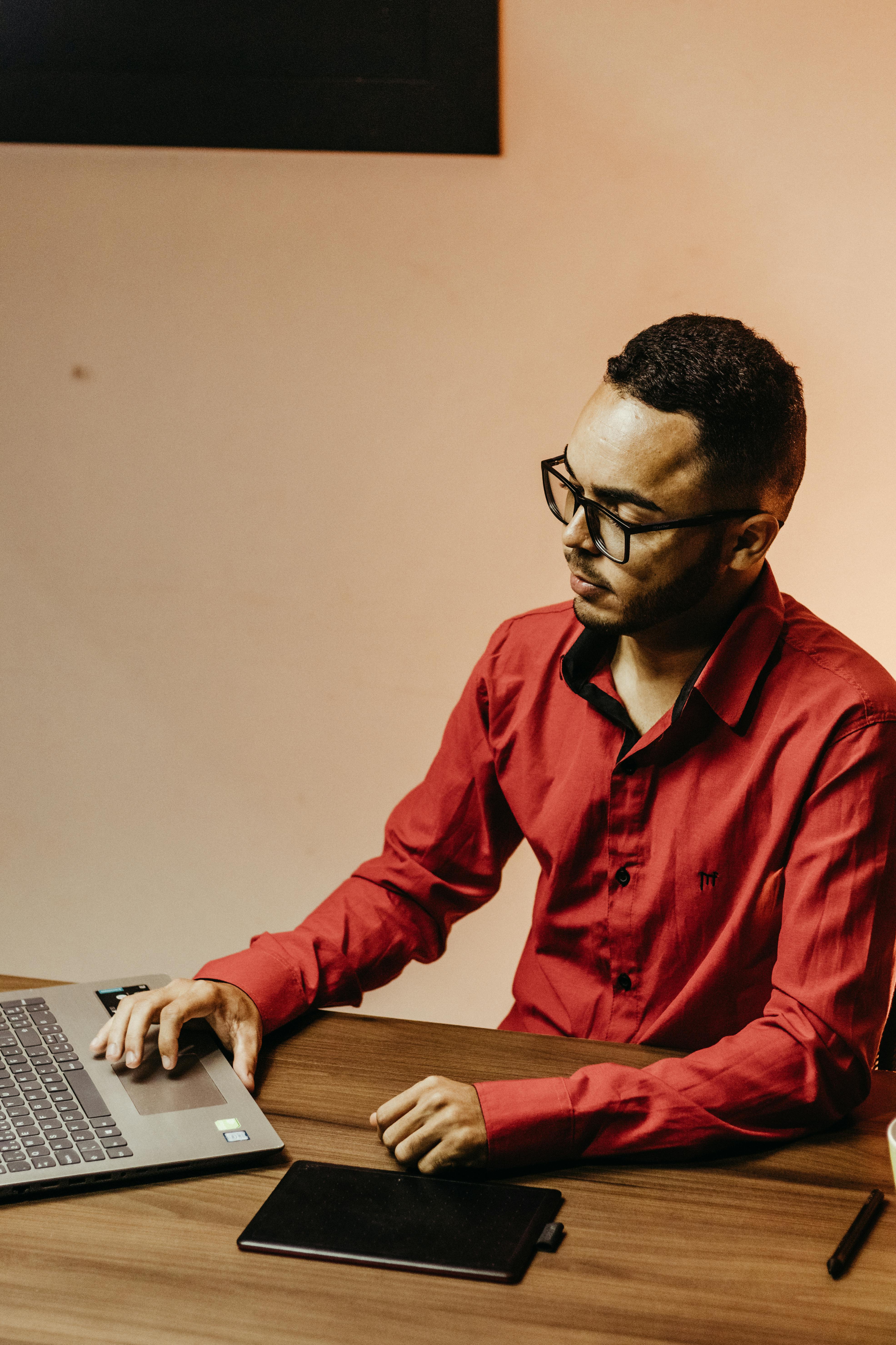Man Sitting Behind Desk, Using Laptop · Free Stock Photo