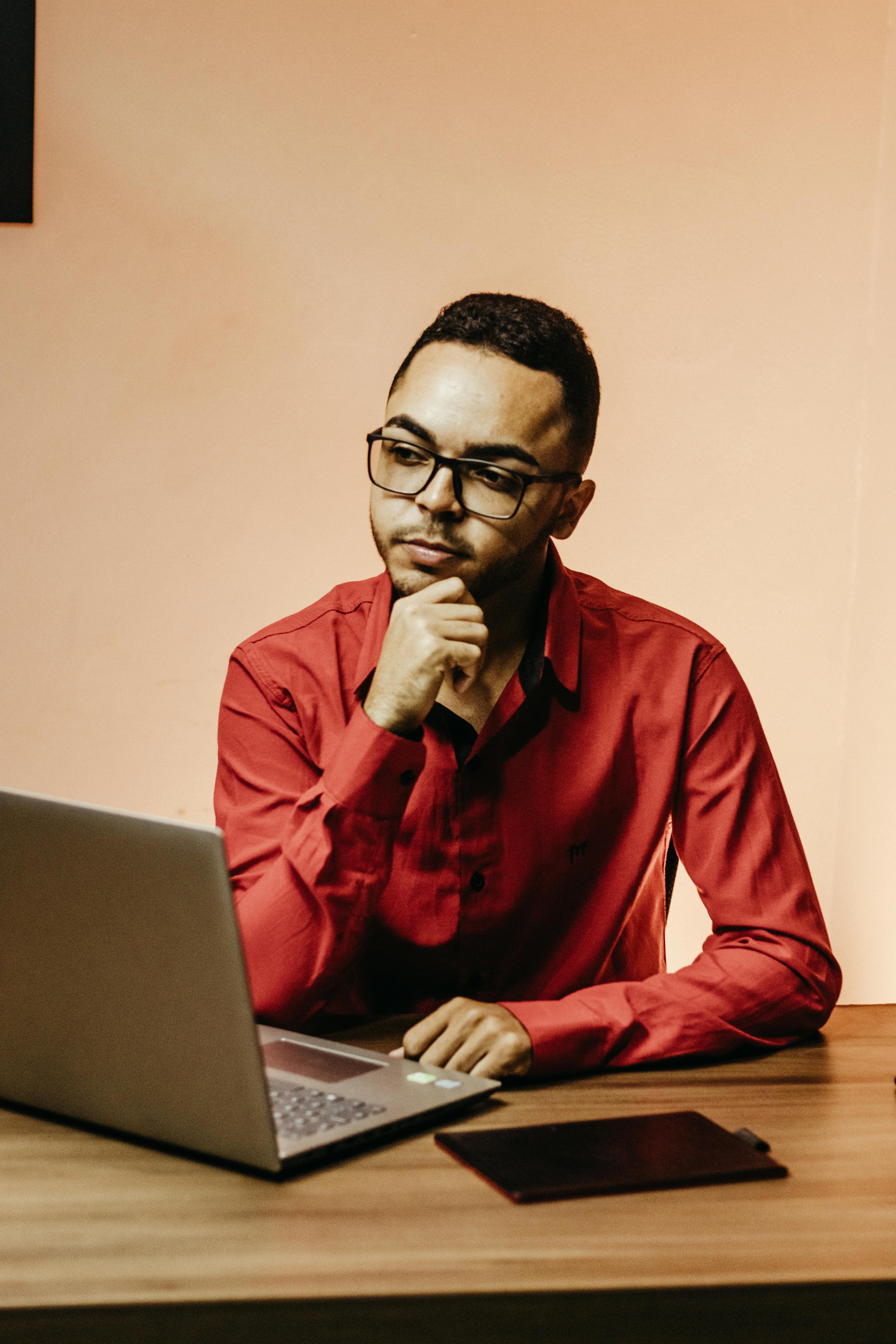 Man Sitting Behind Desk, Using Laptop · Free Stock Photo