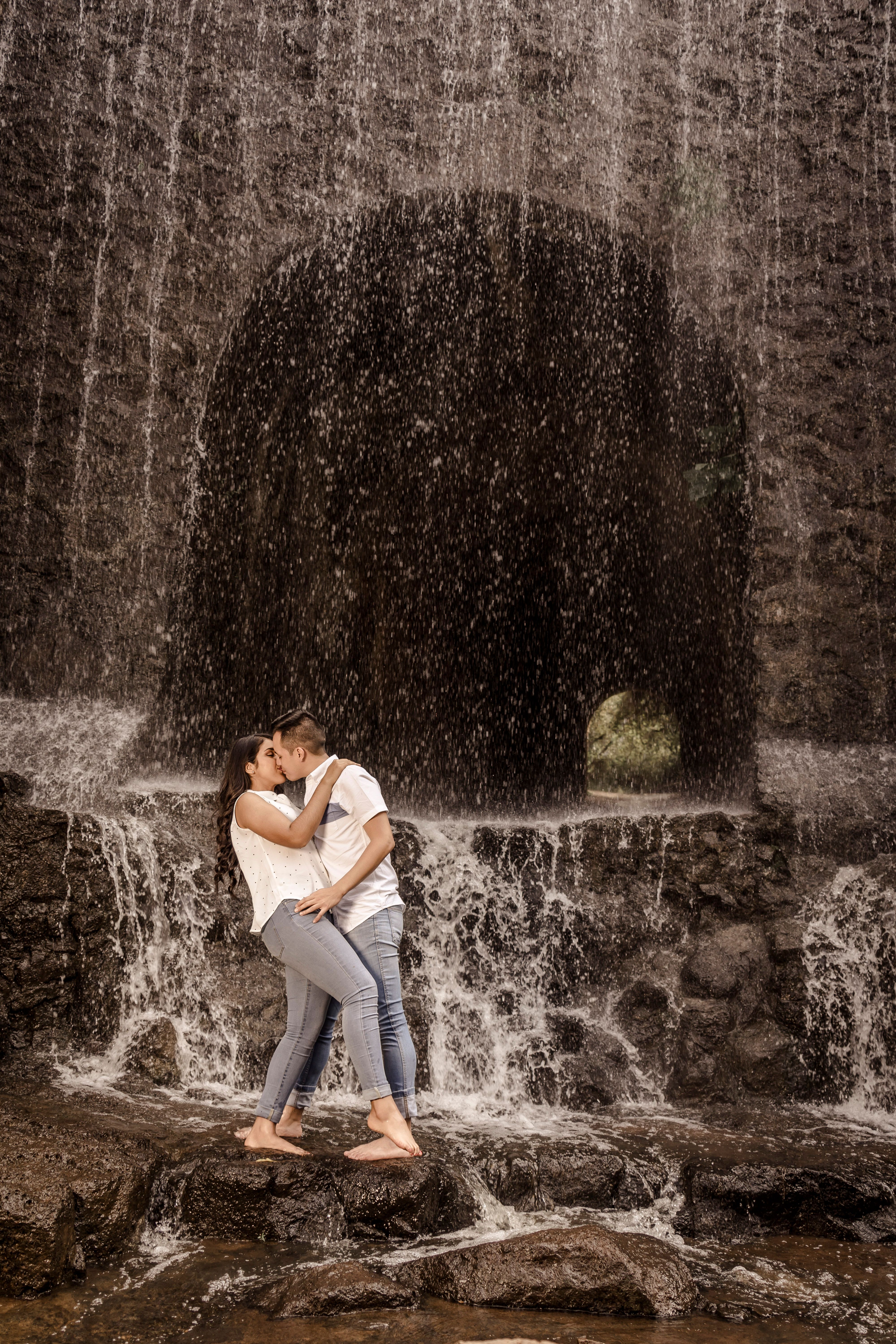 Smiling Couple Kissing under the Waterfall · Free Stock Photo