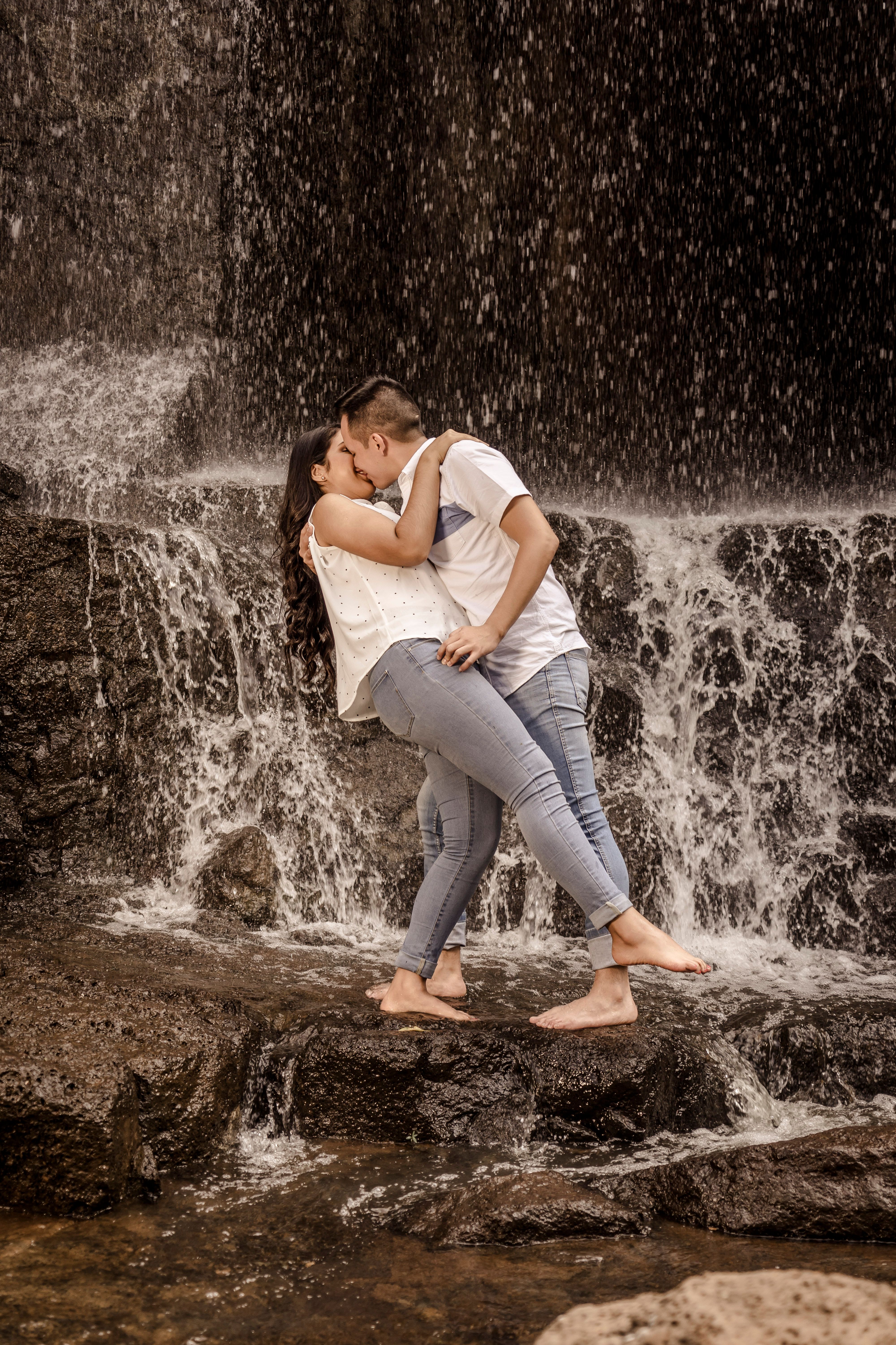Couple Kissing Under Waterfall · Free Stock Photo