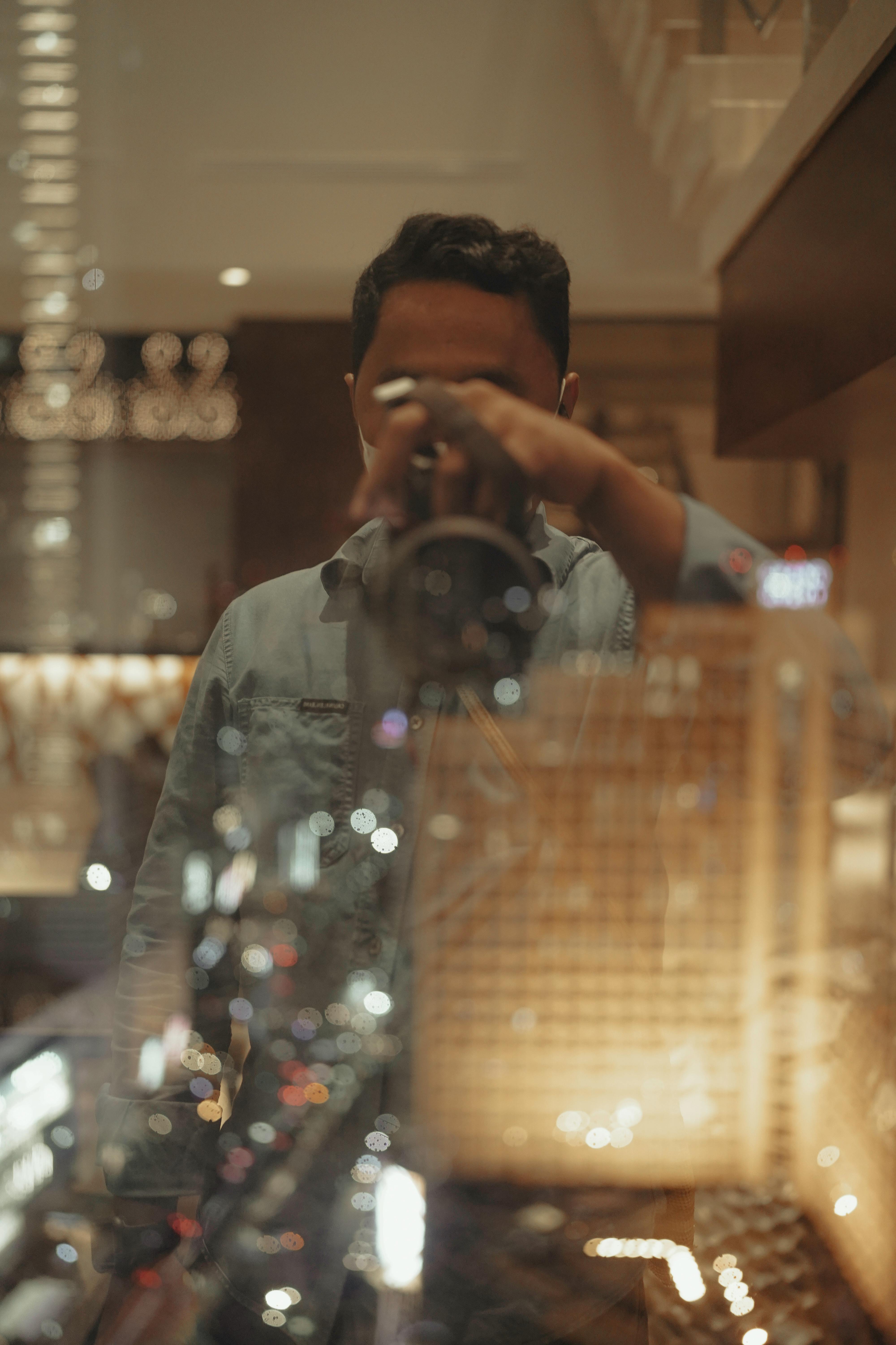 Man Taking Photo of Reflection in Window · Free Stock Photo