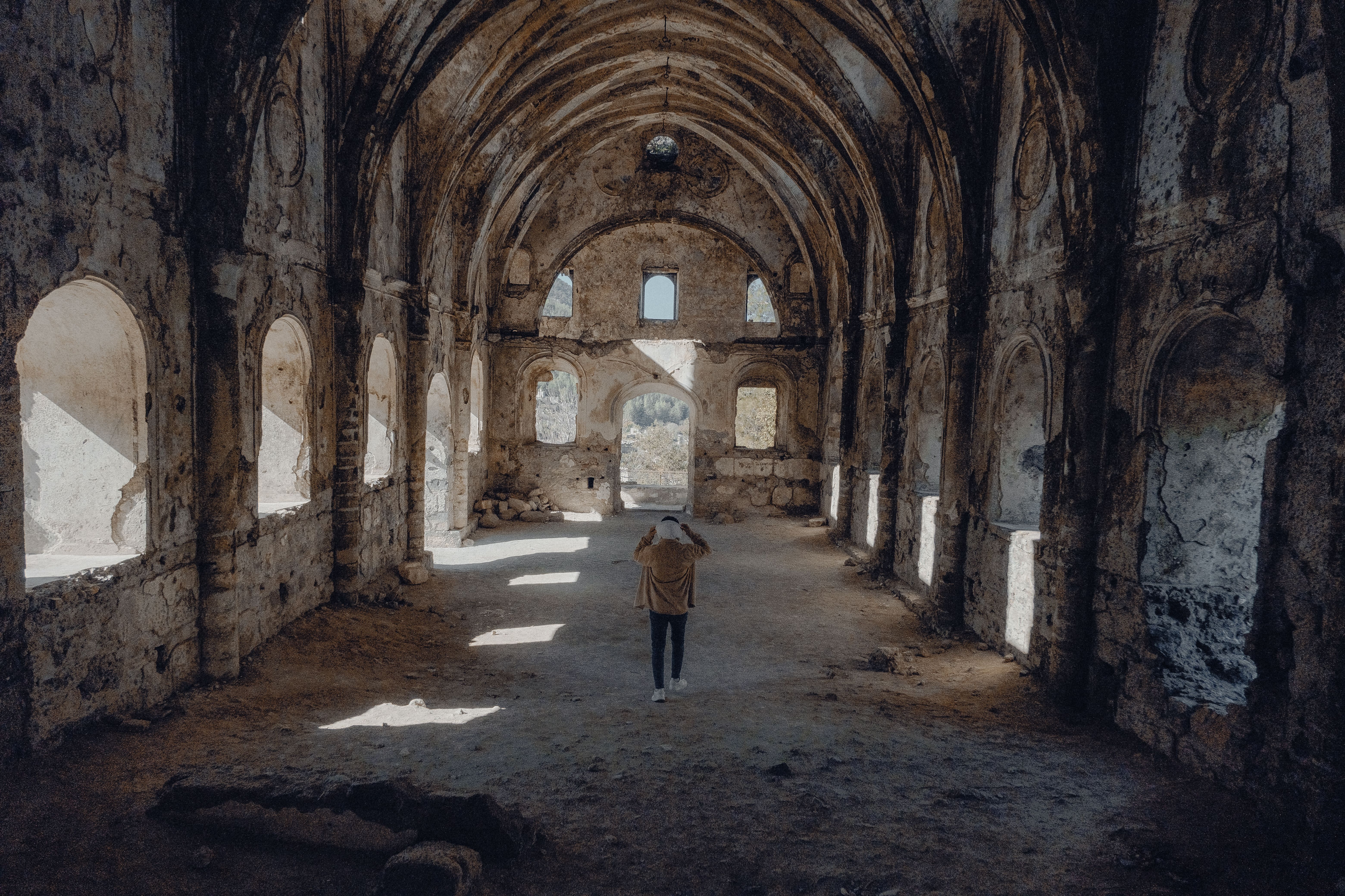 Man in Jacket Exploring Abandoned Church · Free Stock Photo