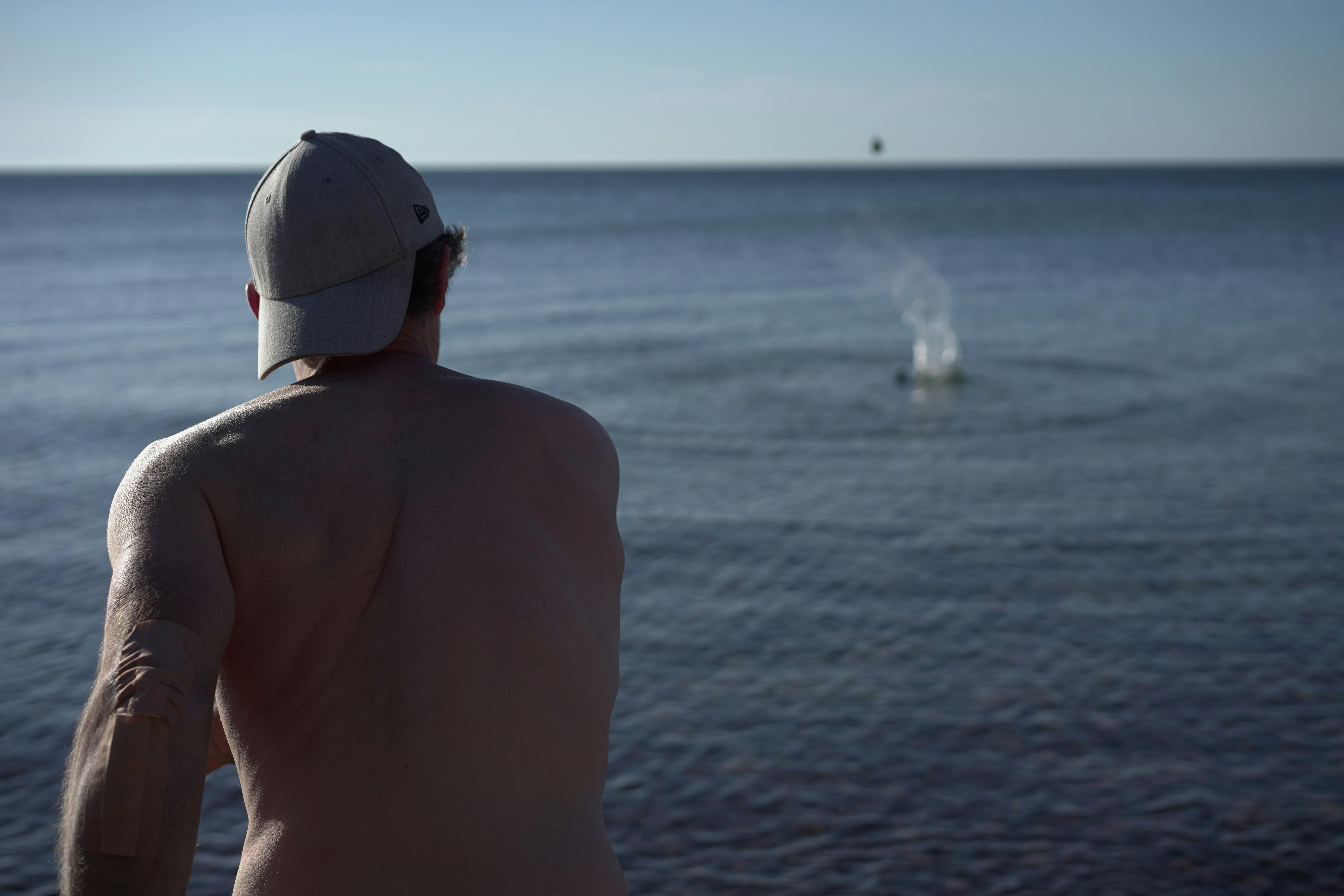 Man Throwing a Stone in the Sea · Free Stock Photo