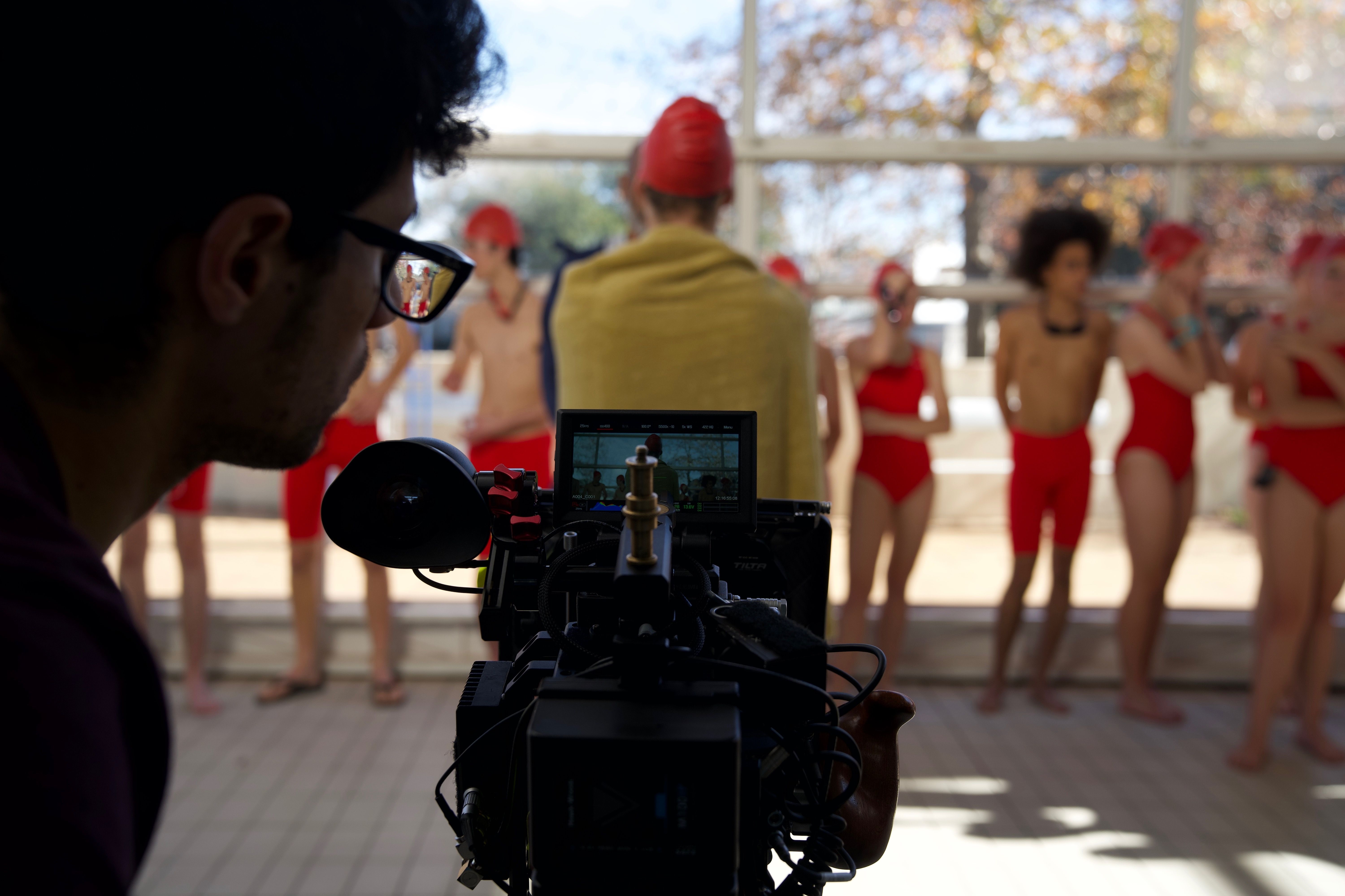 Cameraman Filming a Swim Team · Free Stock Photo
