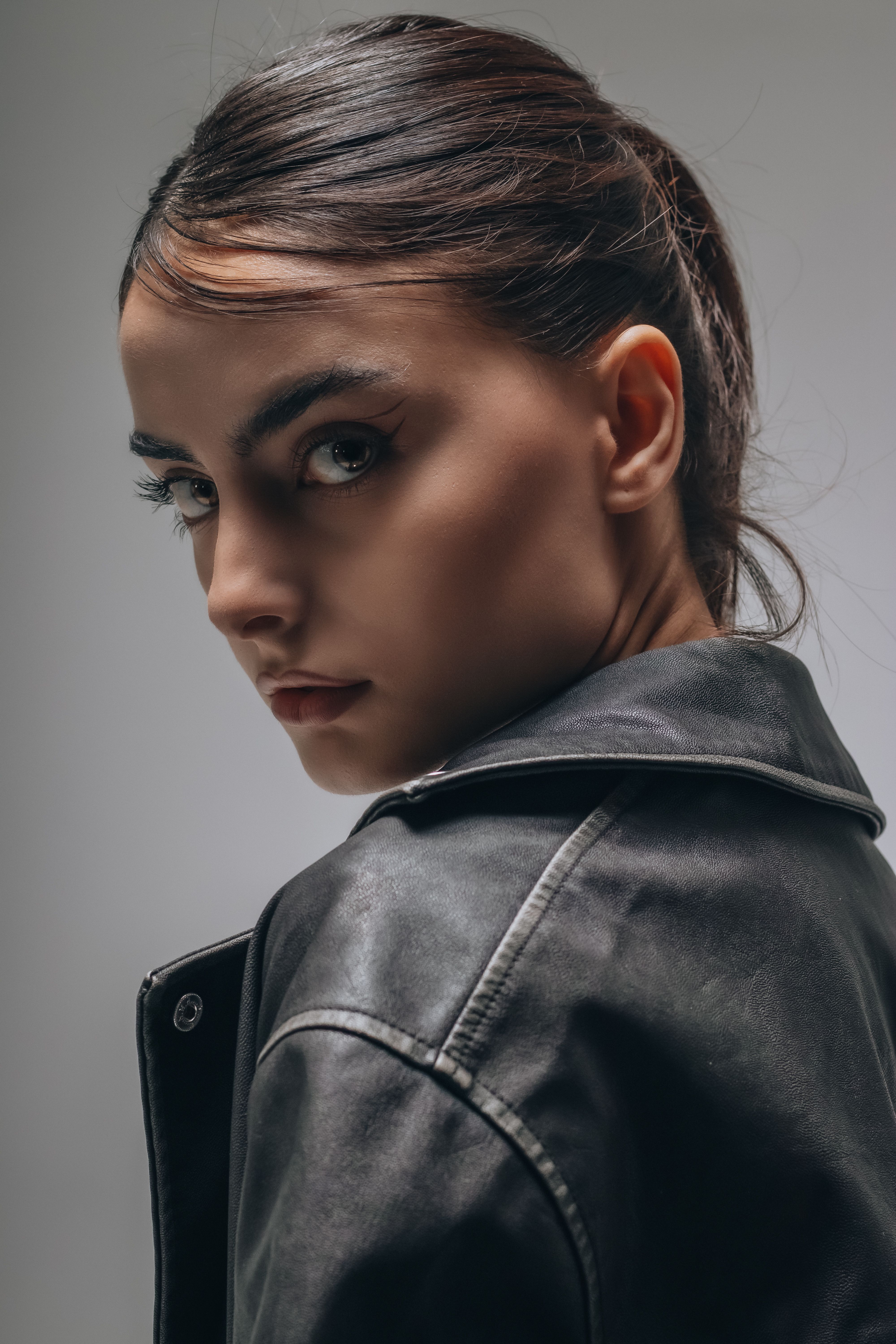 Side View of a Woman in Gray Leather Jacket Wearing Headphones on ...