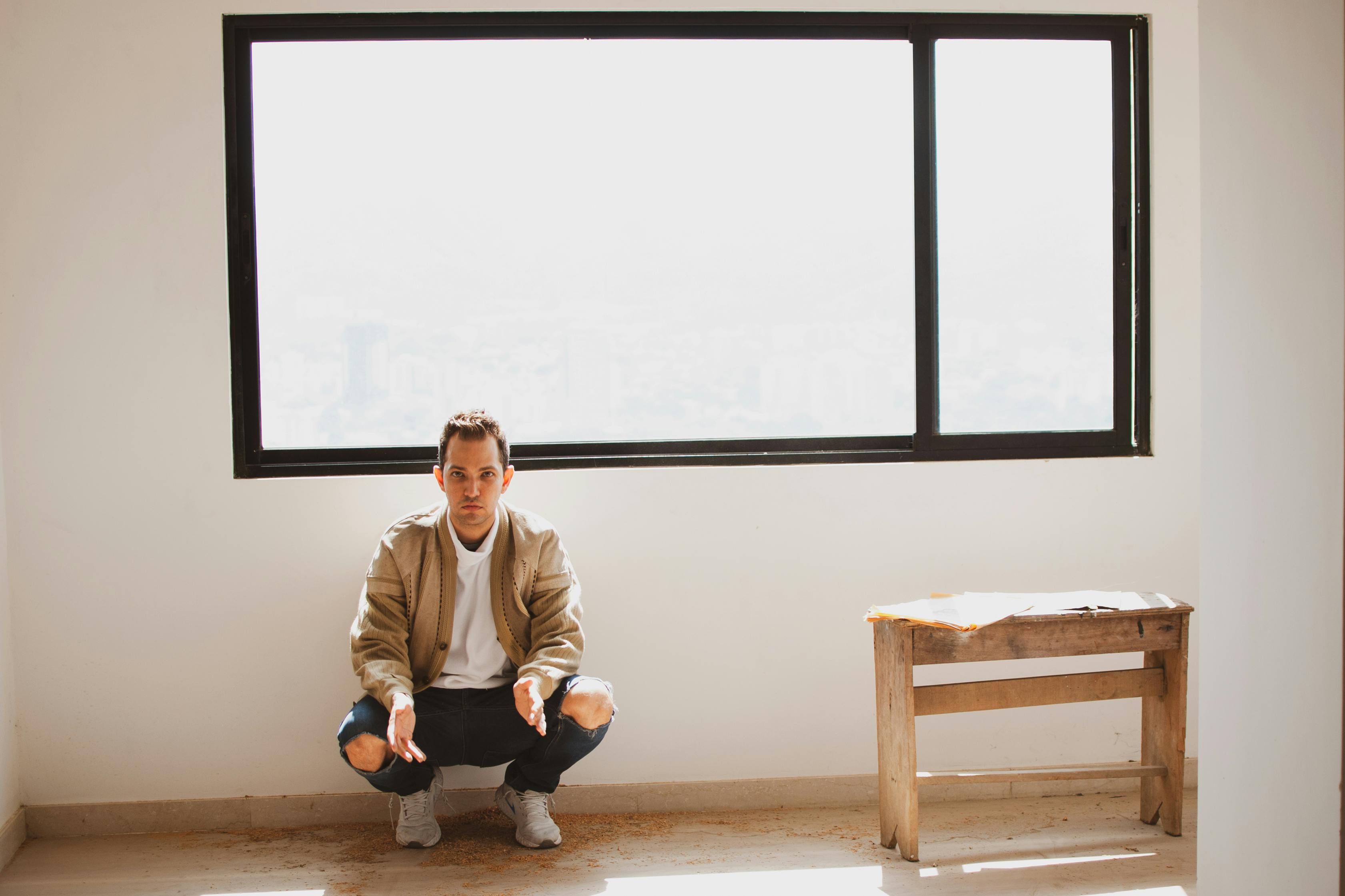 Man Sitting by Neglected House · Free Stock Photo