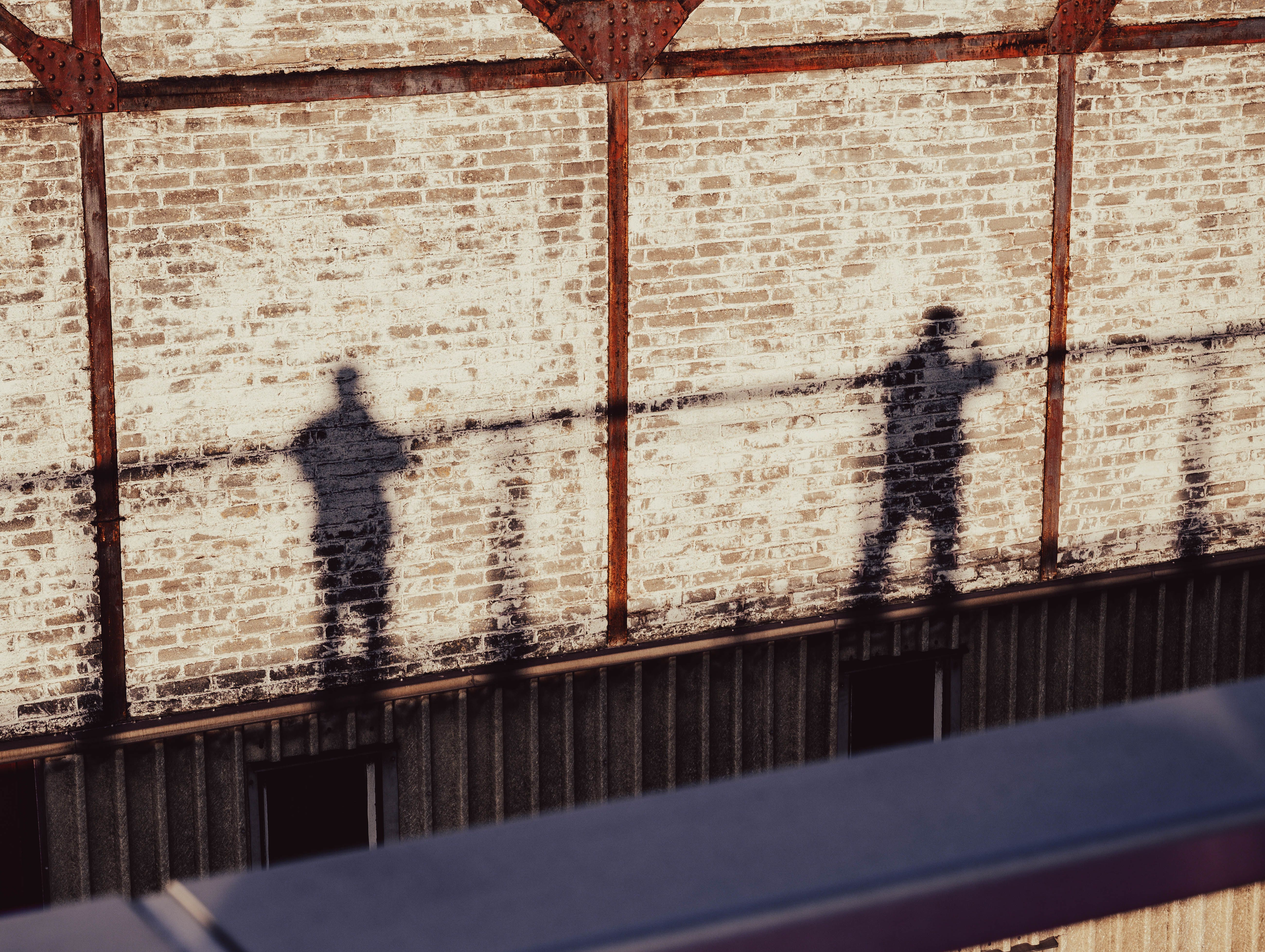 People Shadows on Sunlit Wall · Free Stock Photo