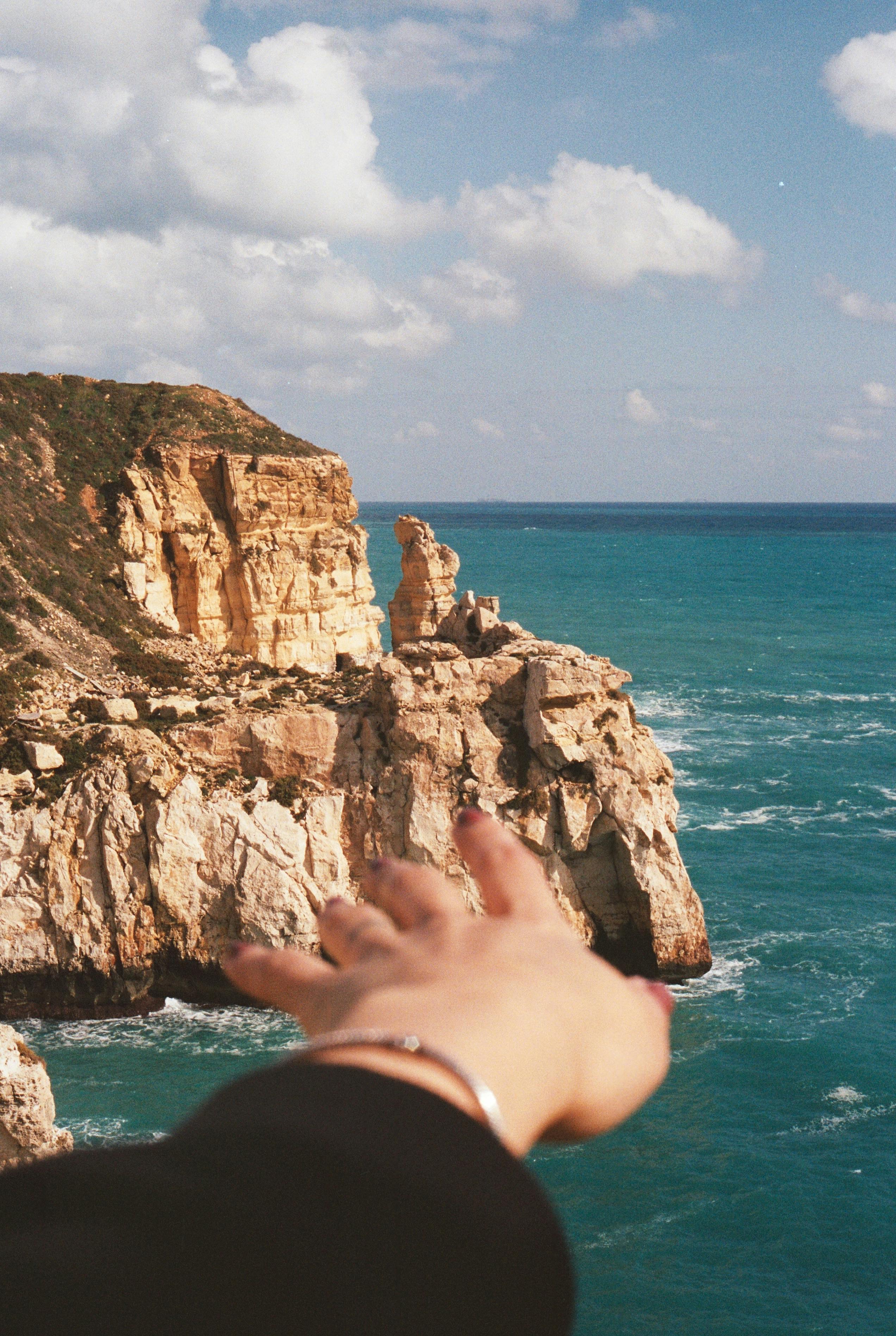 Hand Pointing at Cliff Rocks · Free Stock Photo