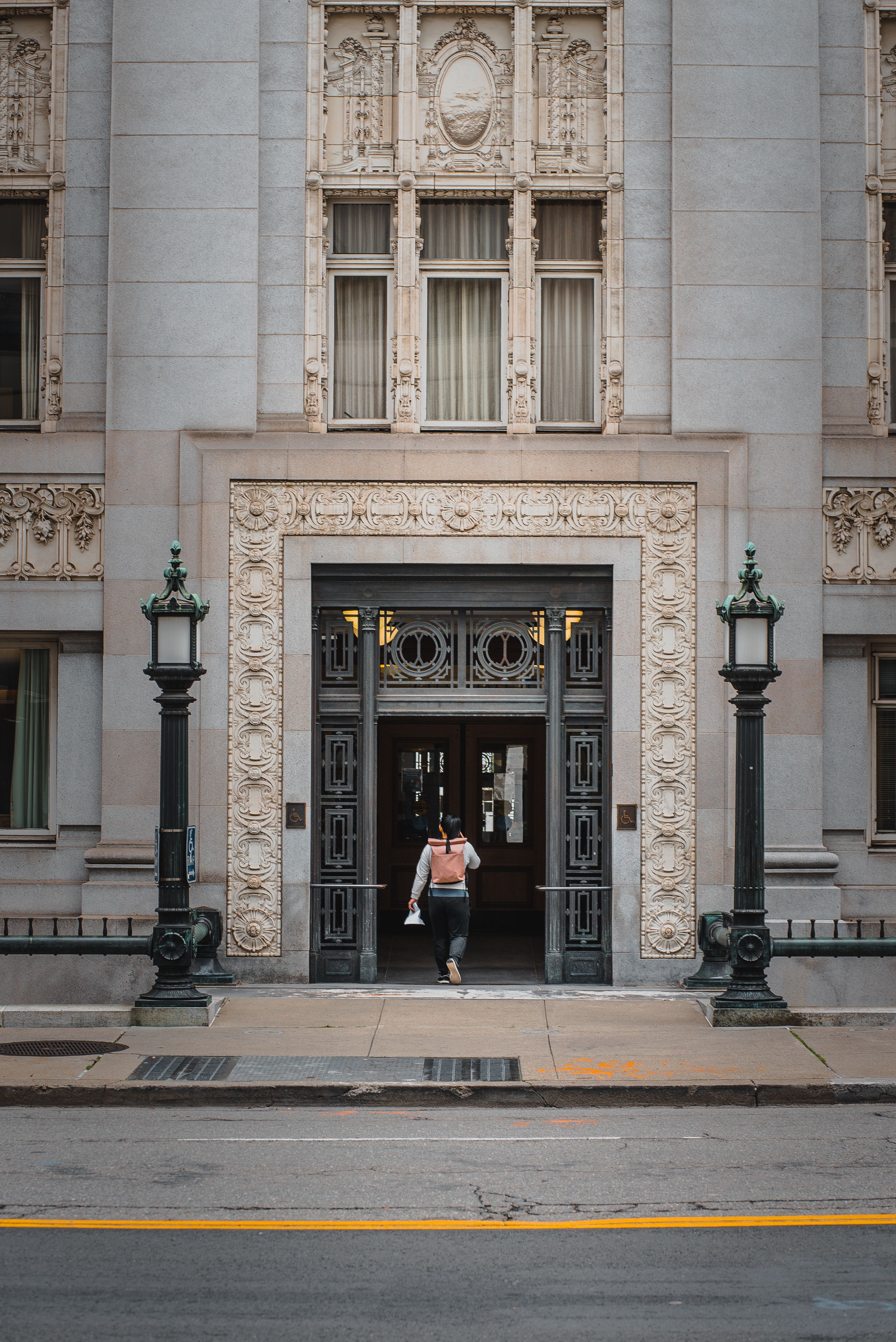A woman is walking into the entrance of a building · Free Stock Photo