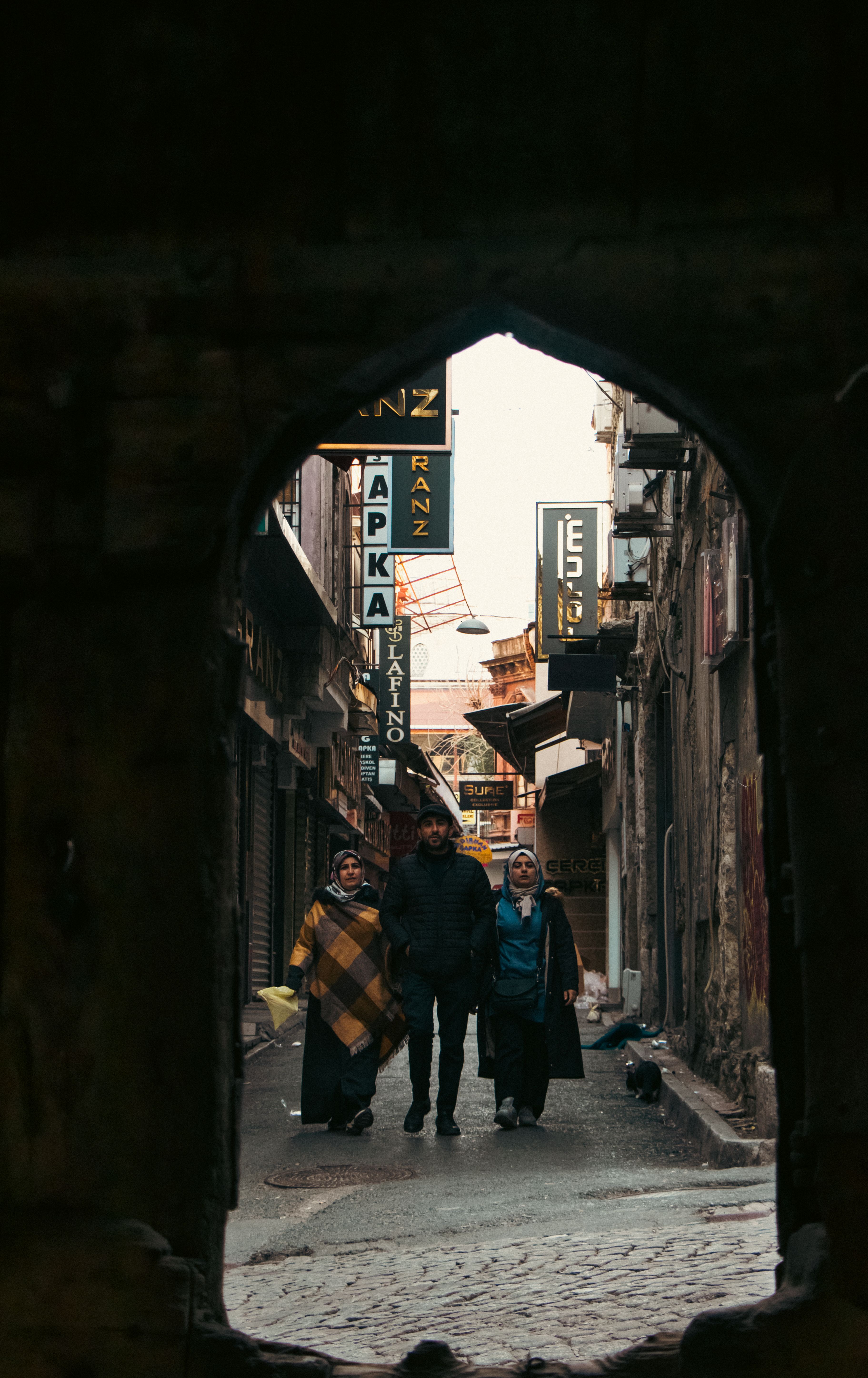 People Walking in an Alley between Buildings in City · Free Stock Photo