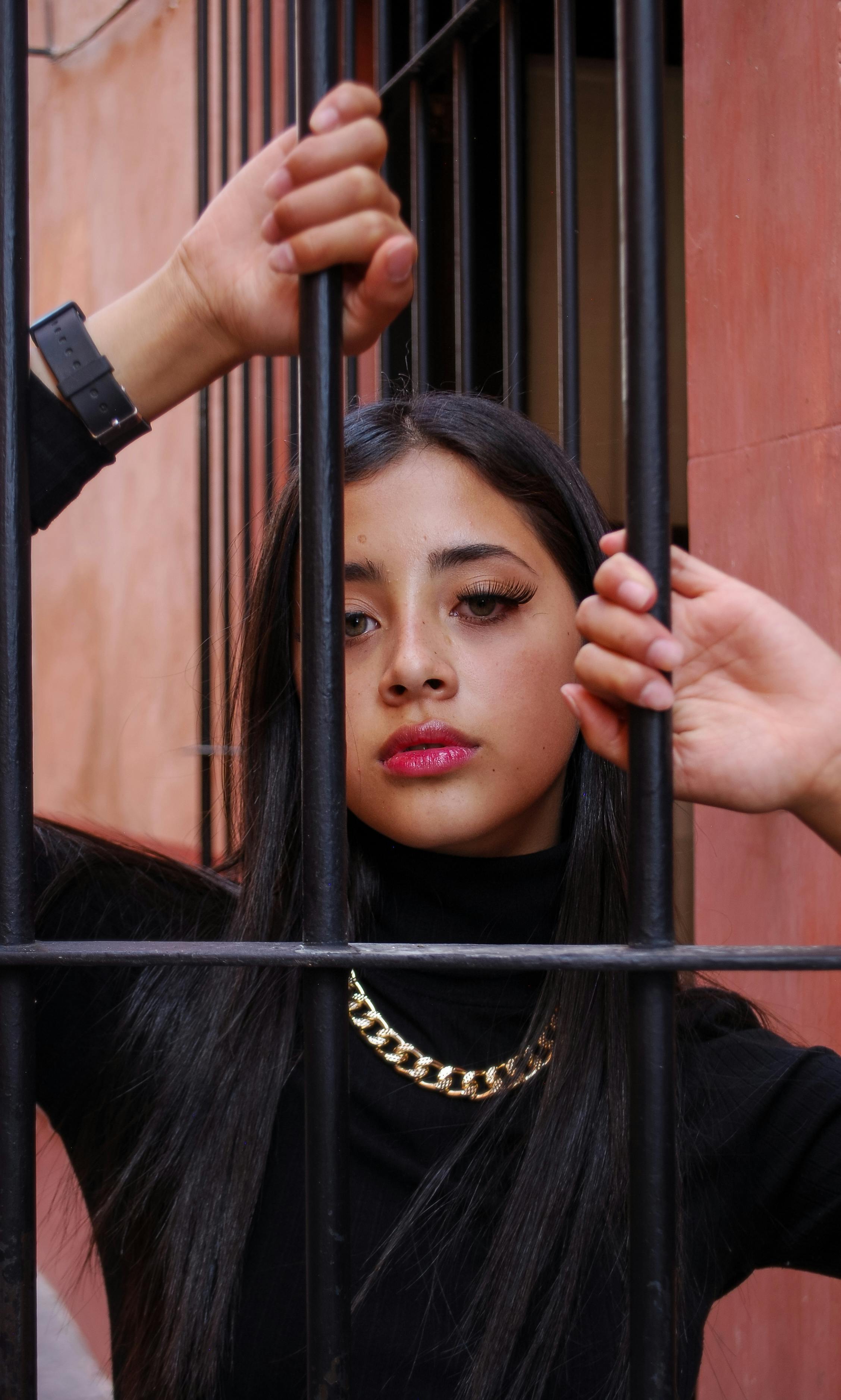 Brunette Woman Posing behind Bars · Free Stock Photo