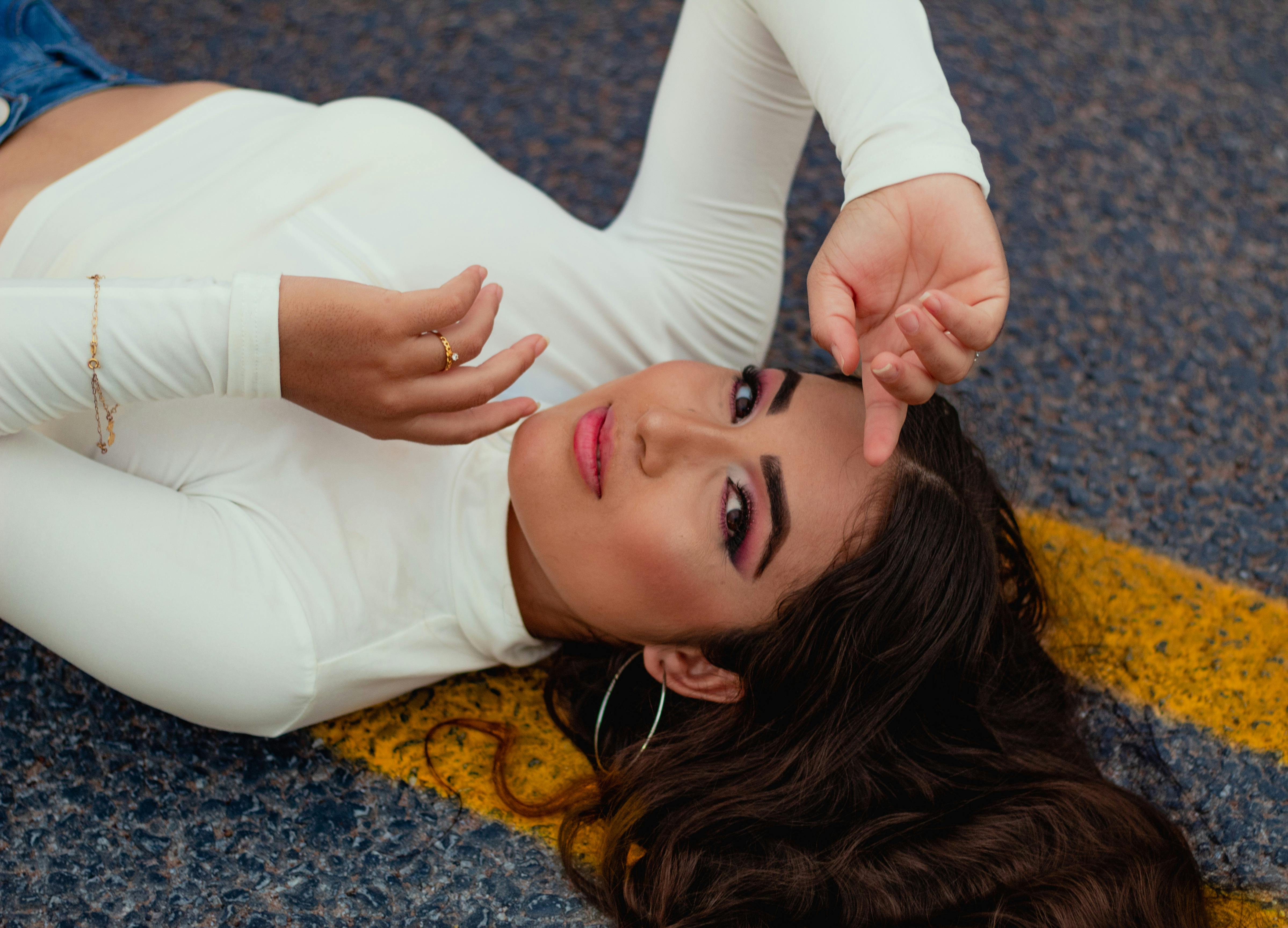 Woman Lying Down and Posing on Pavement · Free Stock Photo