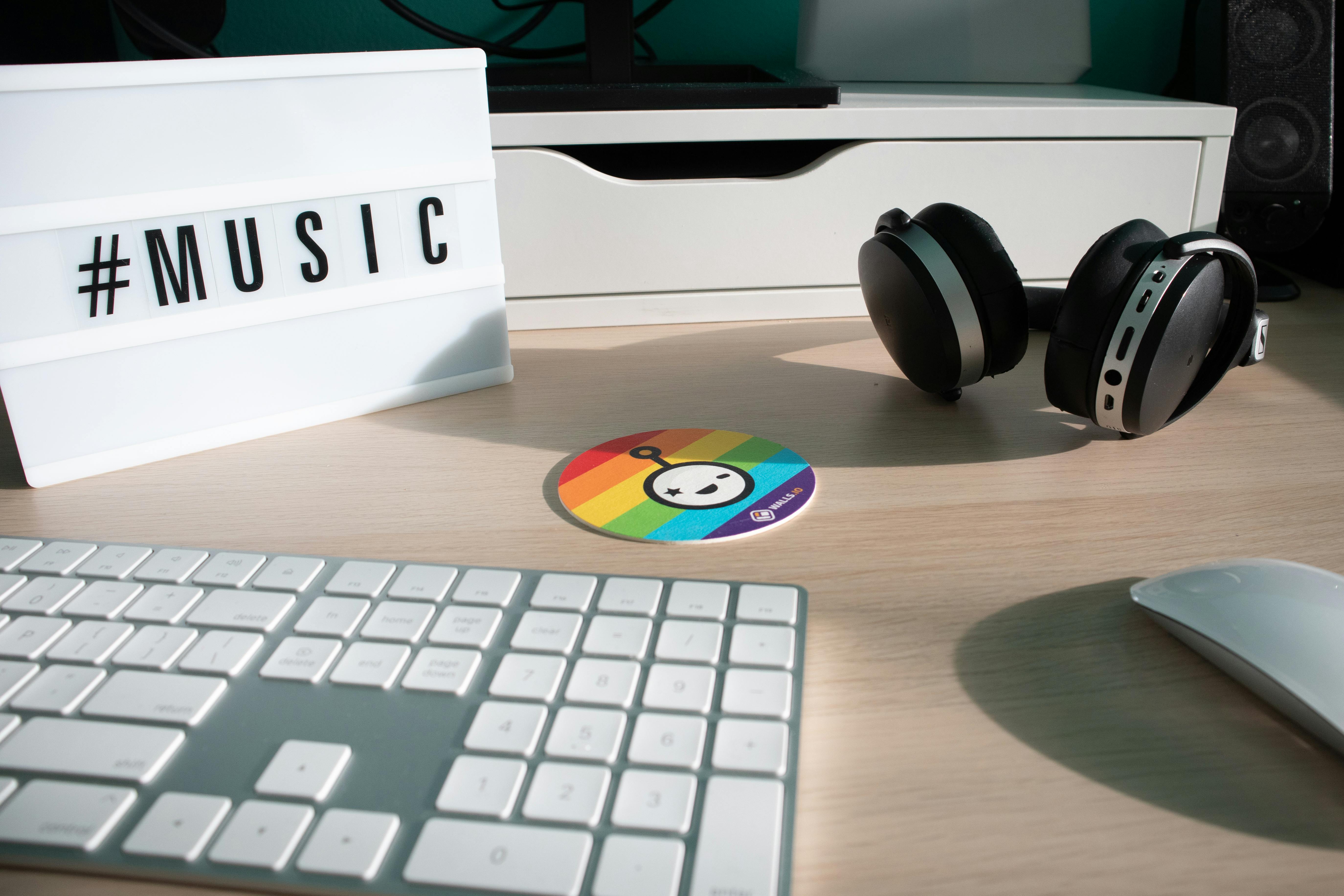 Desk with computer, headphones and a light box with the hashtag #music ...