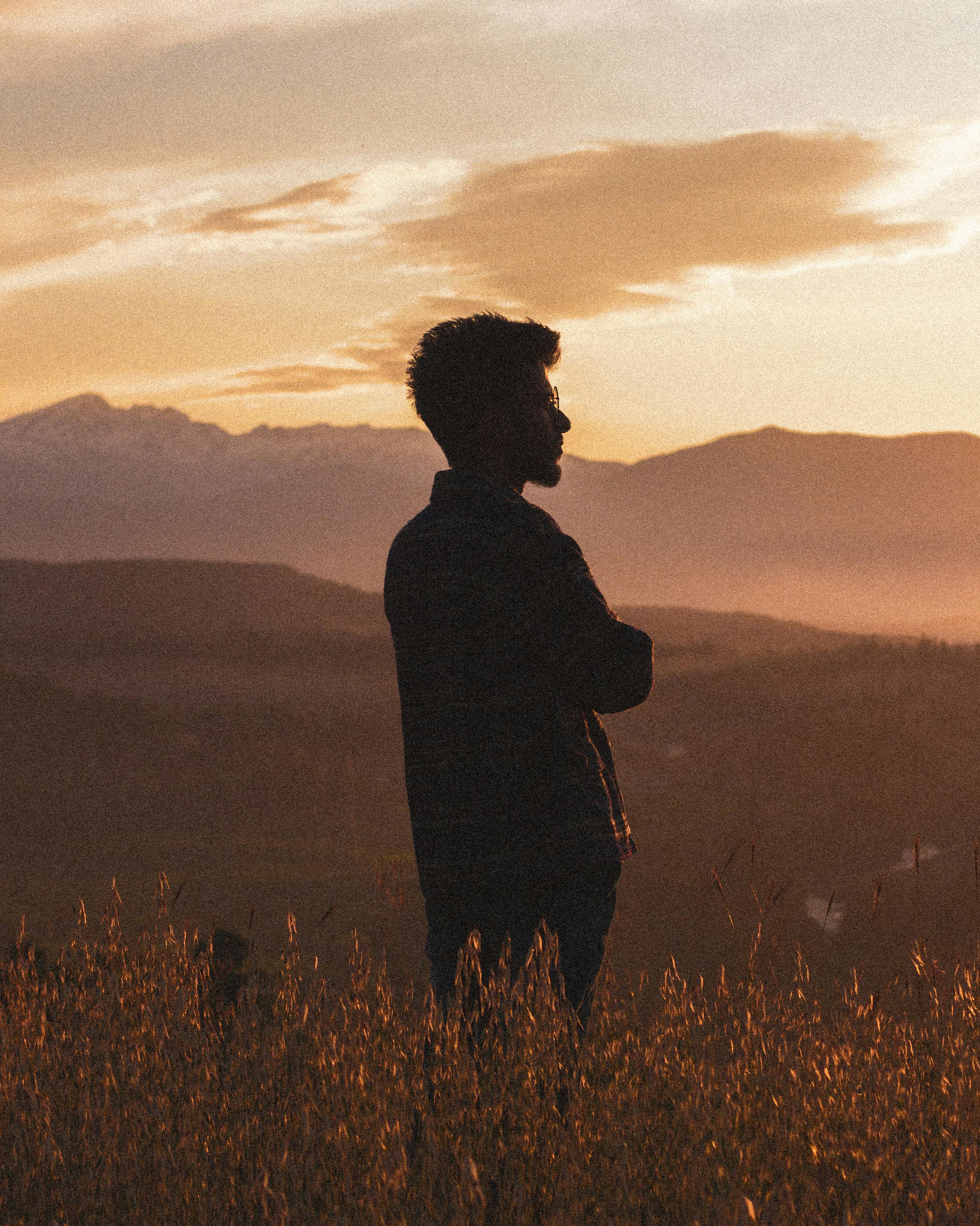 Standing Man on a Meadow at Sunset · Free Stock Photo