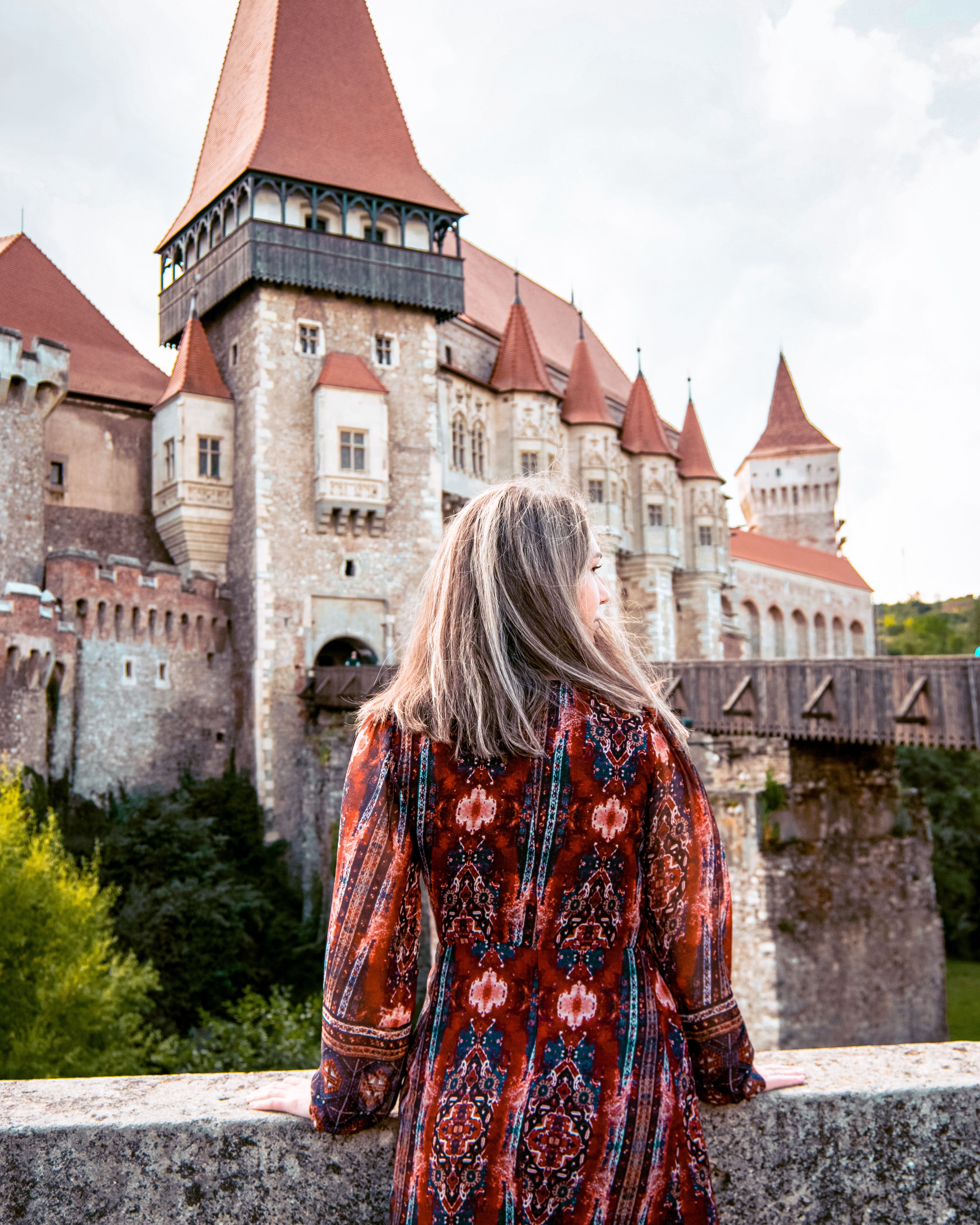 Woman Standing in front of Corvin Castle in Transylvania, Romania ...
