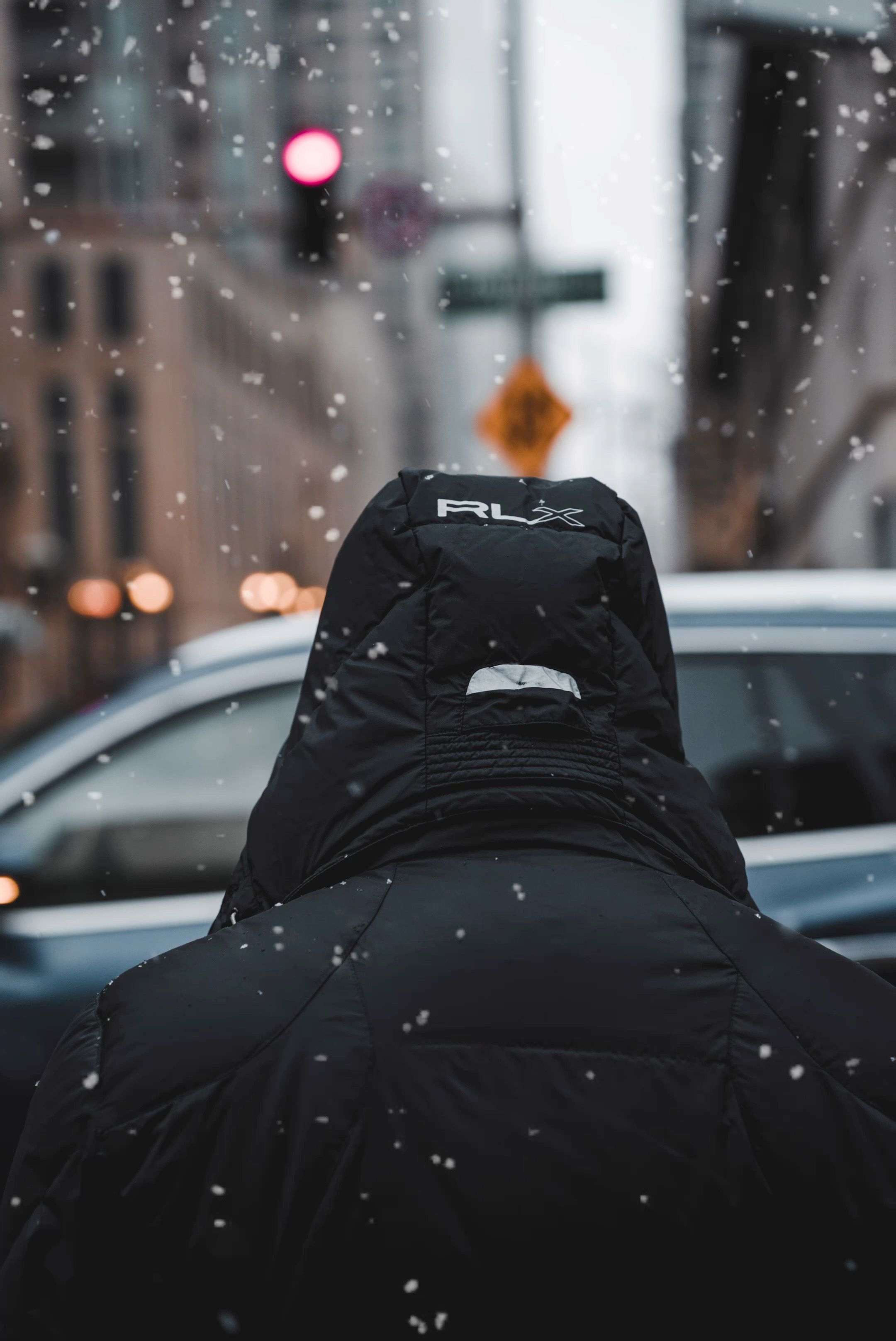 Snowfall over Person in Jacket with Hood in City in USA · Free Stock Photo