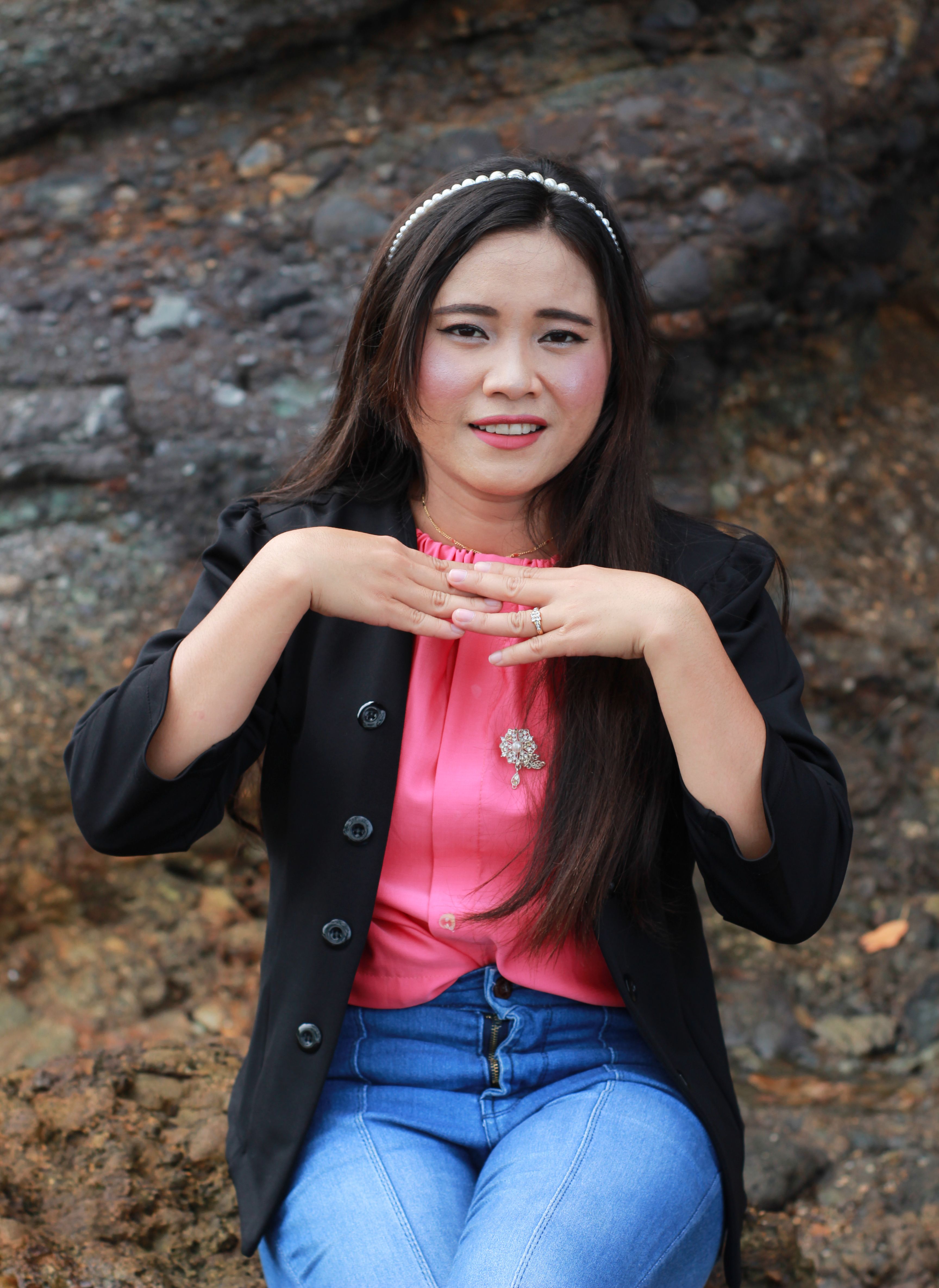 Woman Sitting and Posing with Rock behind · Free Stock Photo