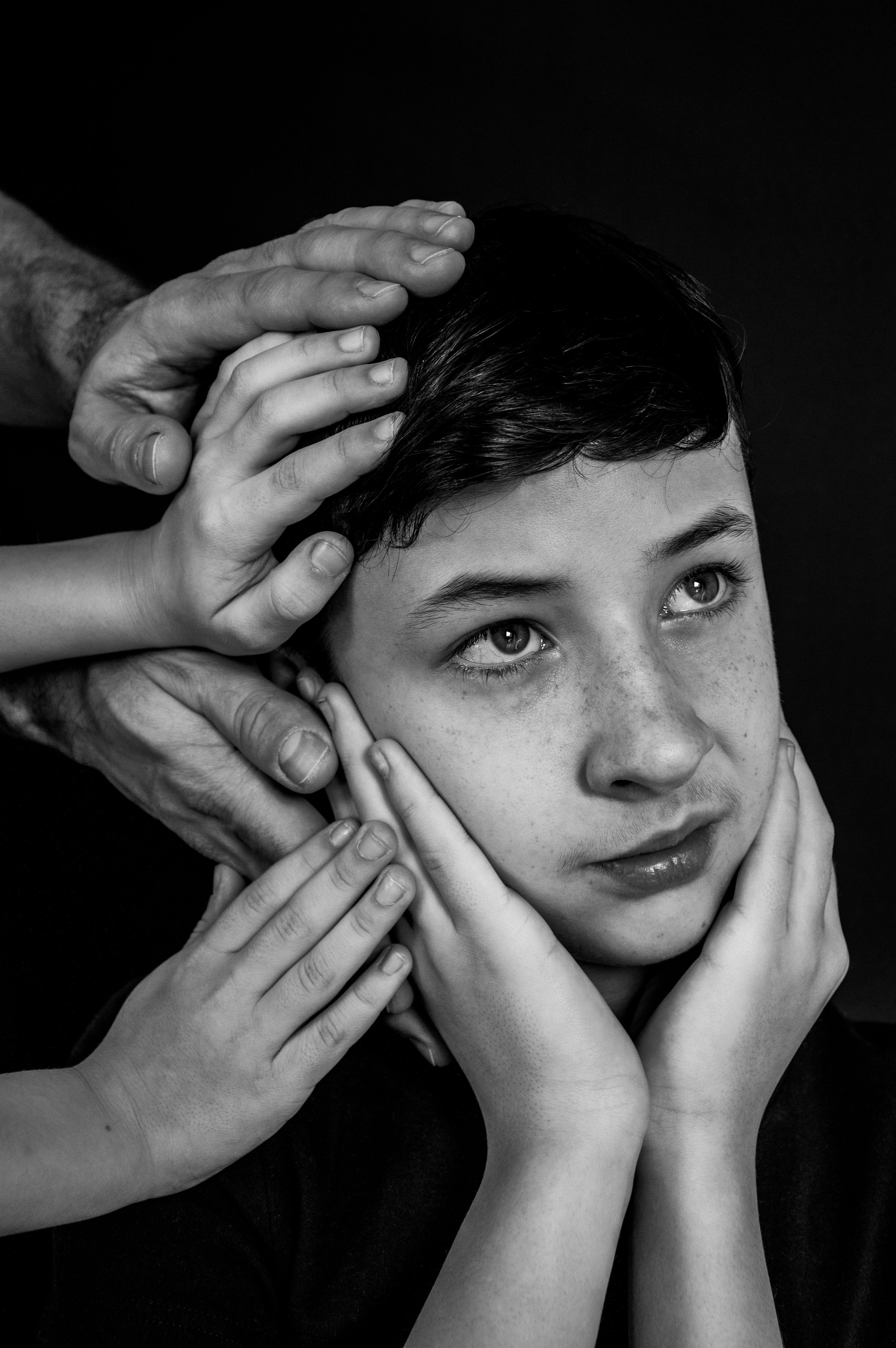 Hands around Boy Face in Black and White · Free Stock Photo