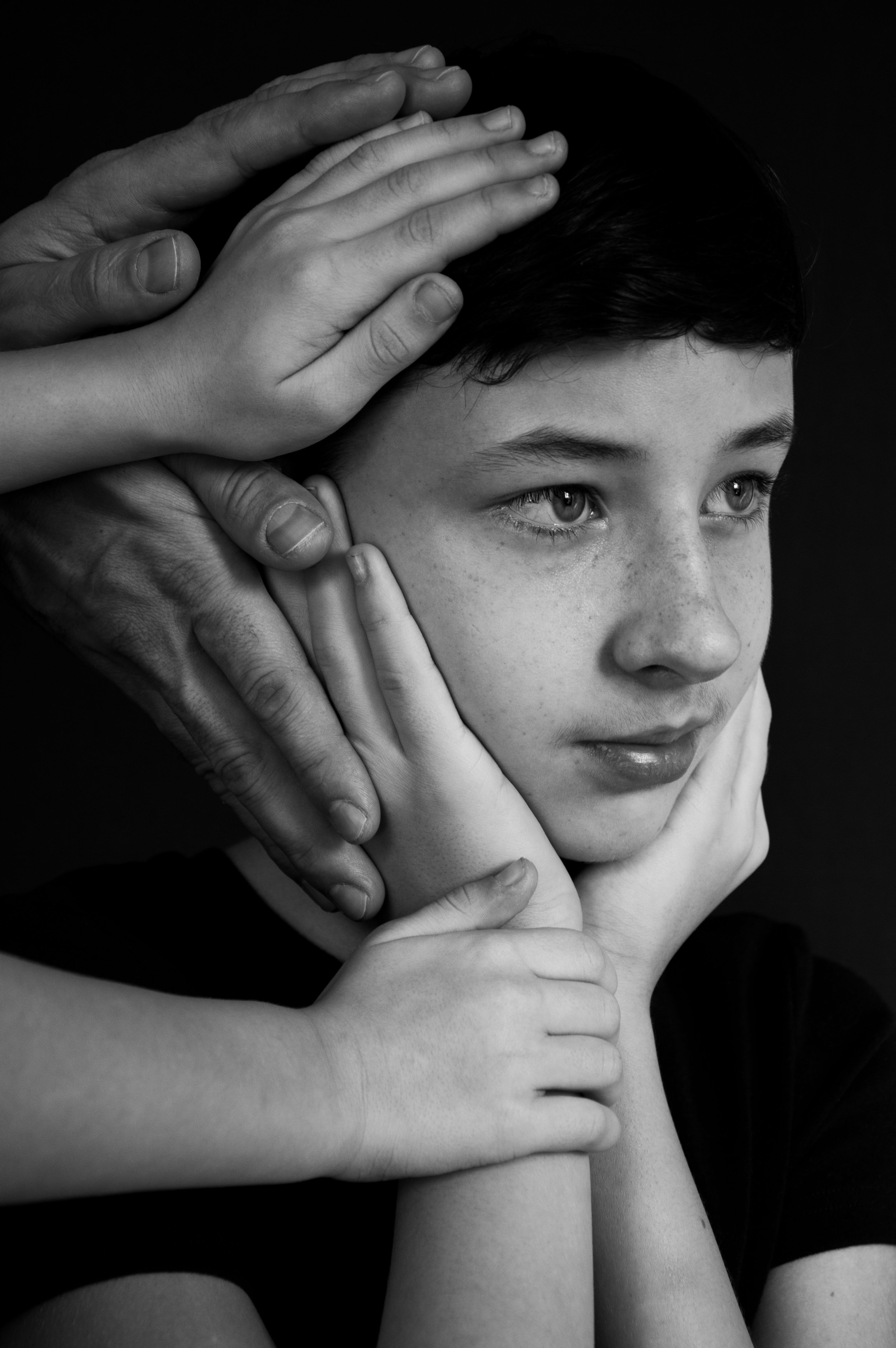 Hands around Boy Face in Black and White · Free Stock Photo