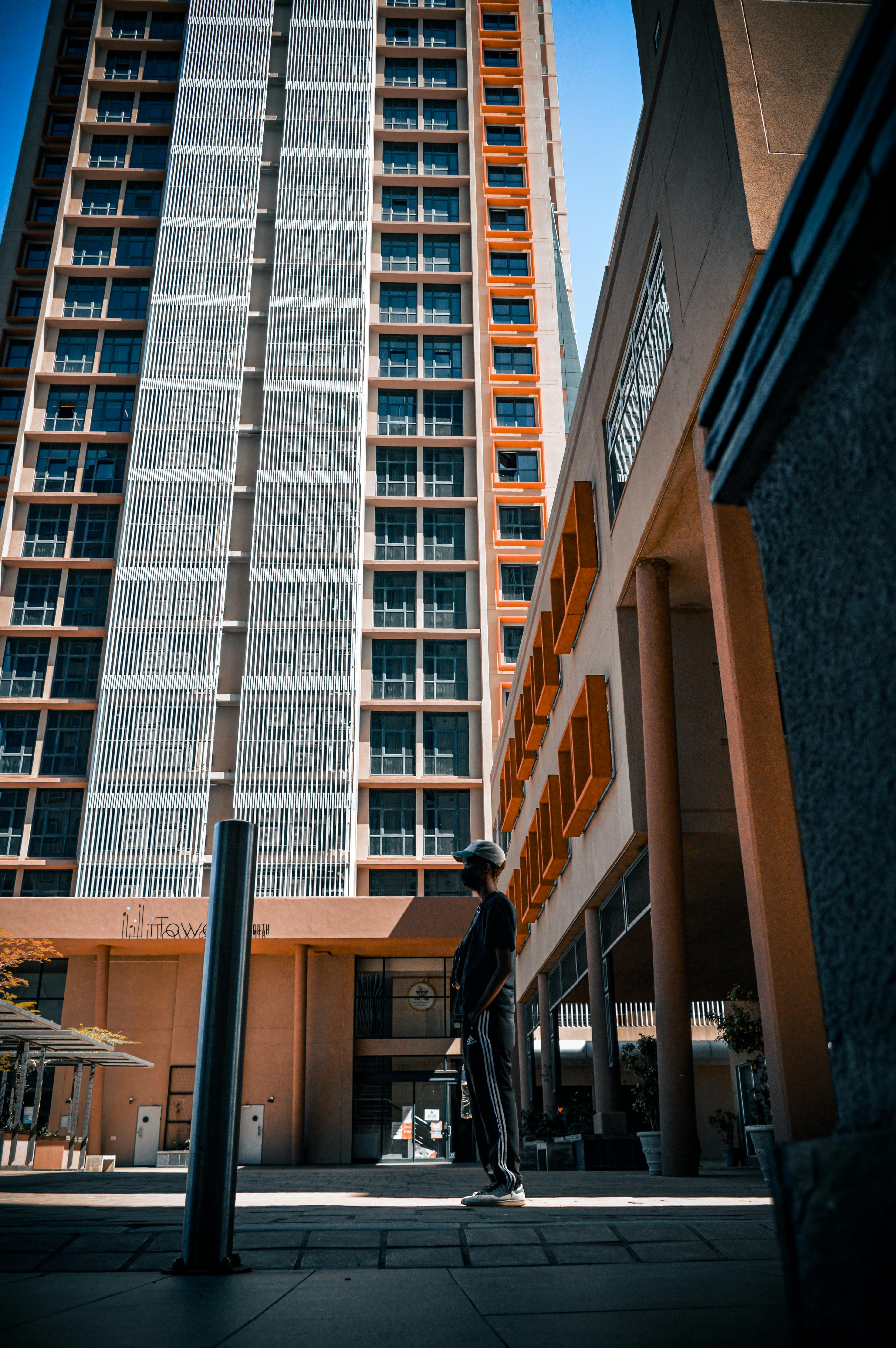 Man Standing under Skyscraper · Free Stock Photo