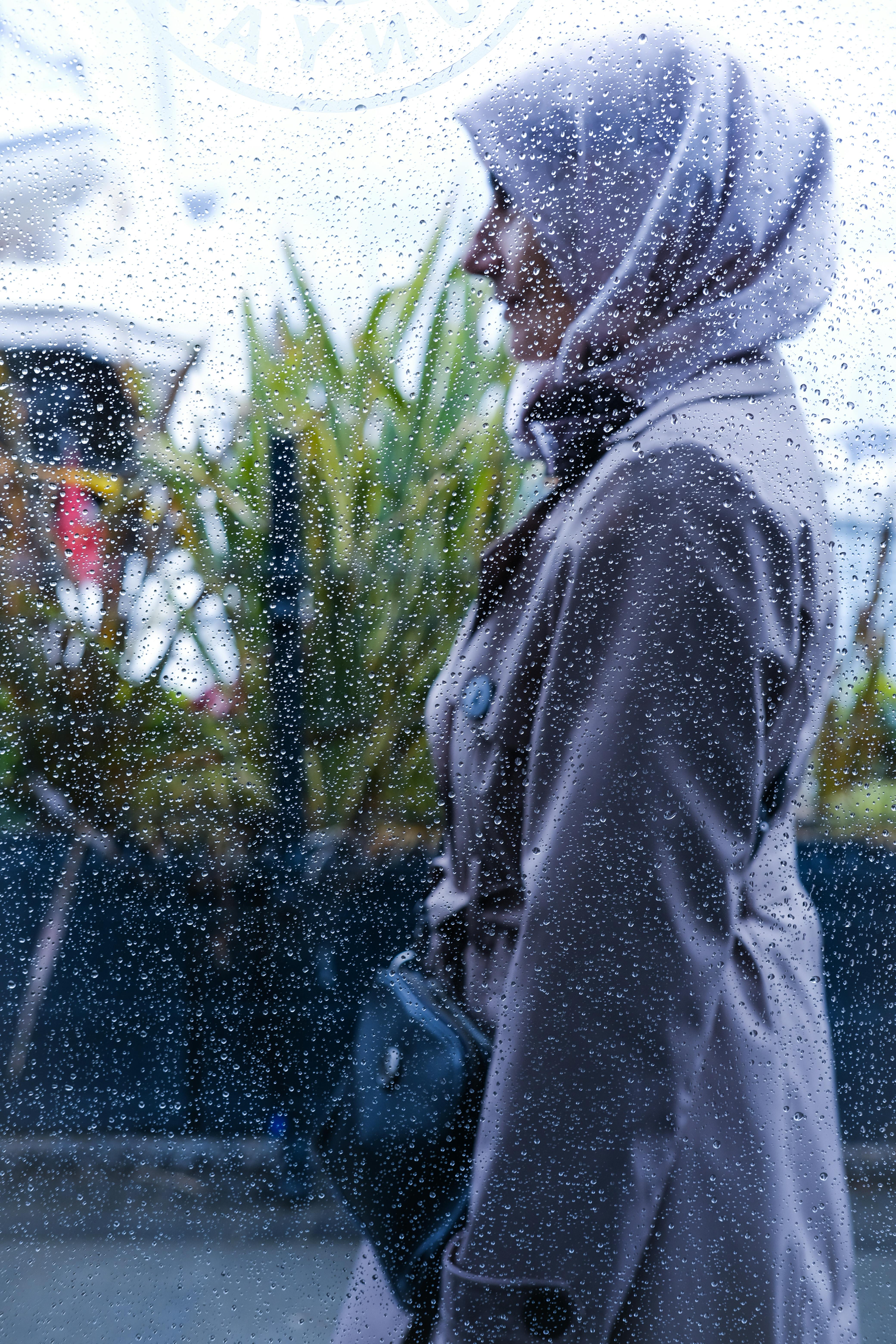 Woman in Coat and Headscarf Seen through Pane in Droplets · Free Stock ...