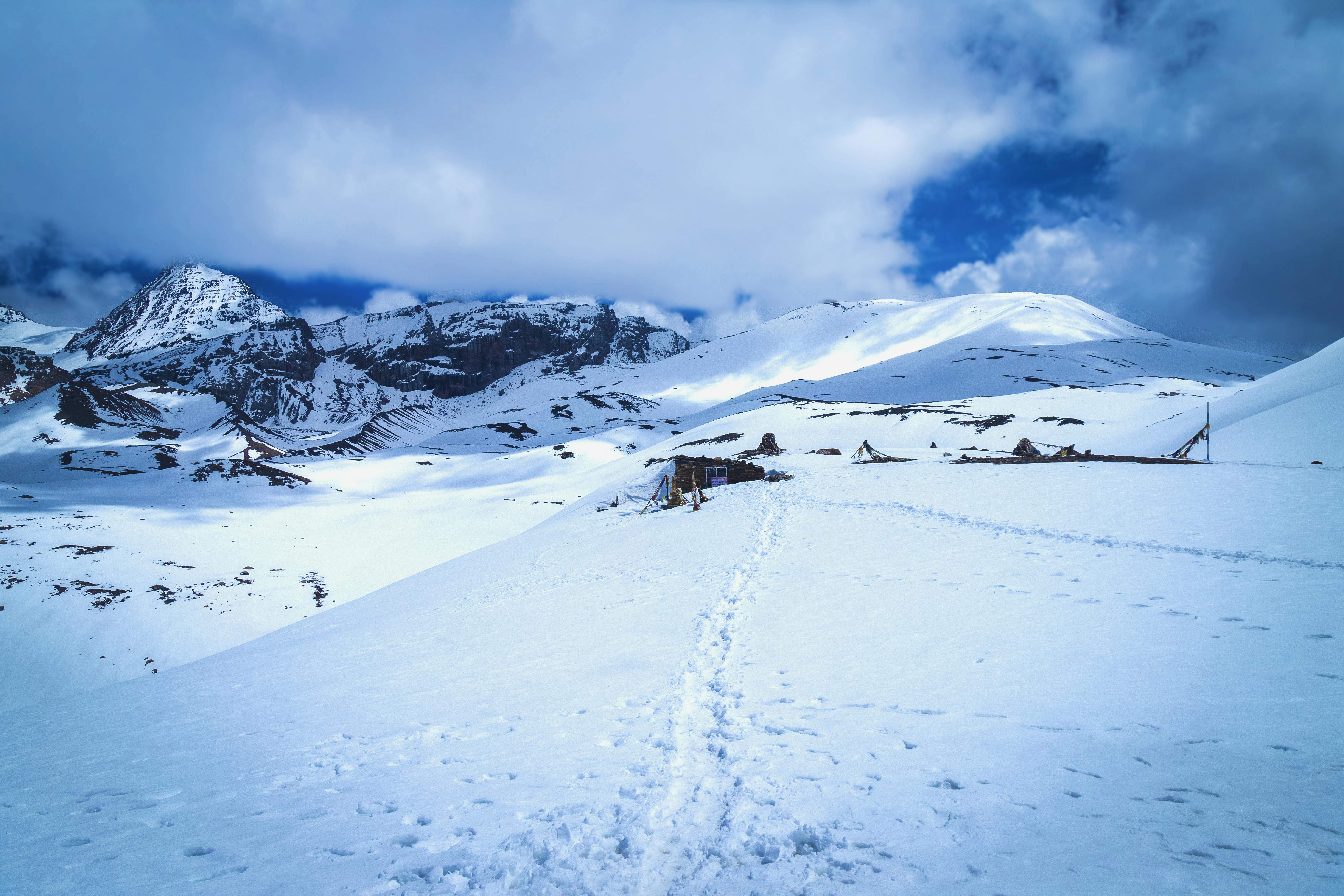 A person walking on a snowy mountain with snow covered mountains in the ...