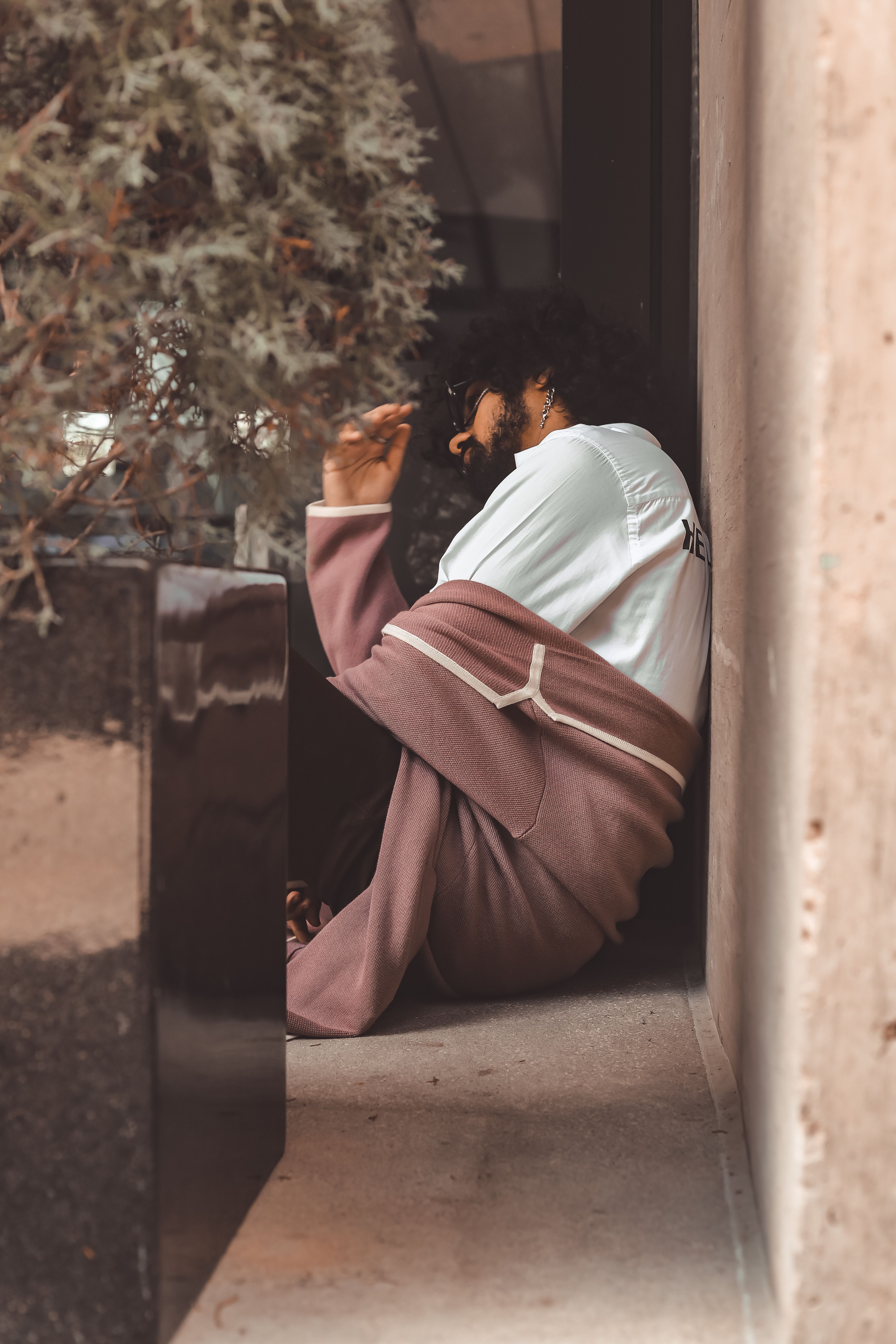 Man Sitting near Wall · Free Stock Photo